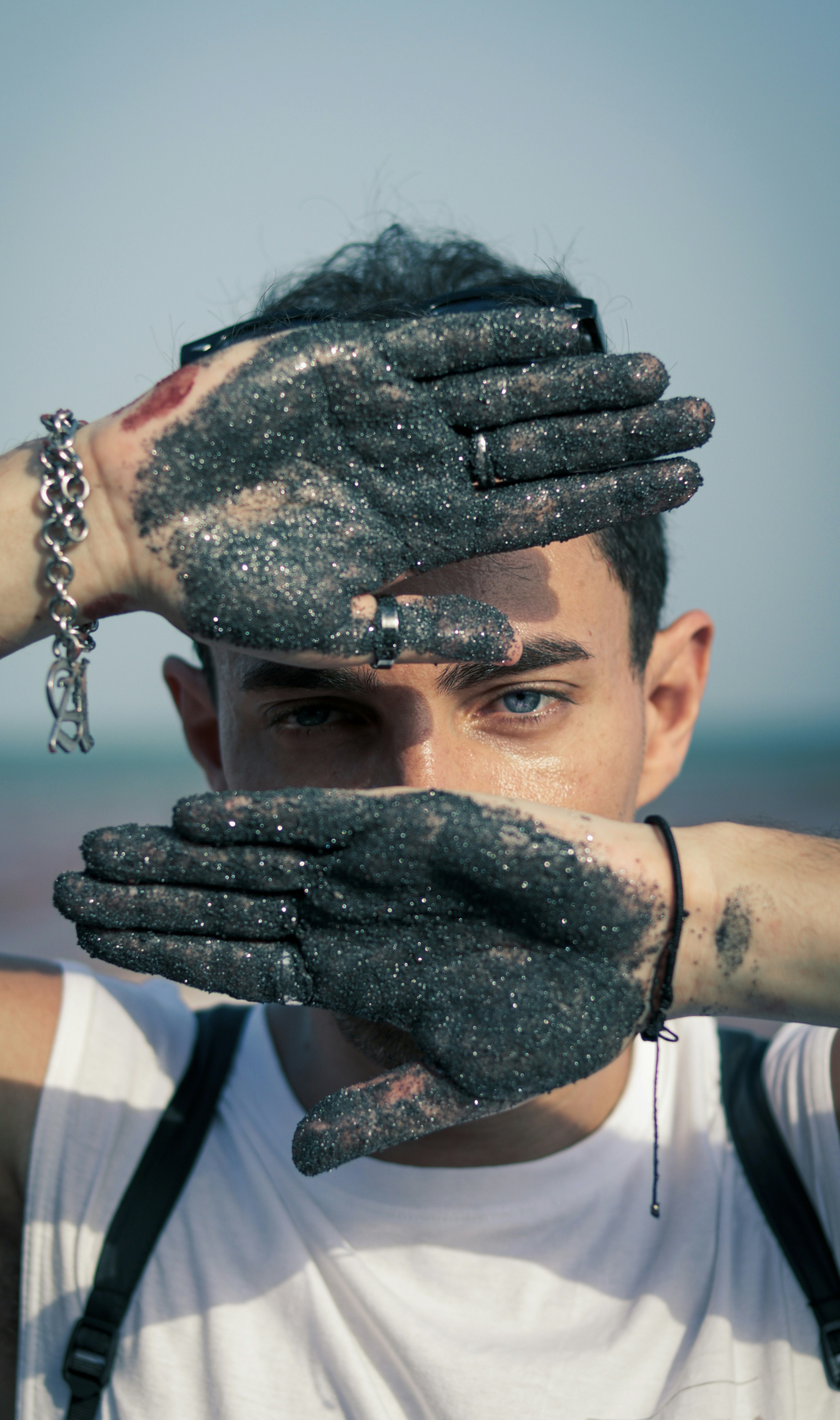 Glittered Hands Frame a Hidden Gaze on the Shoreline