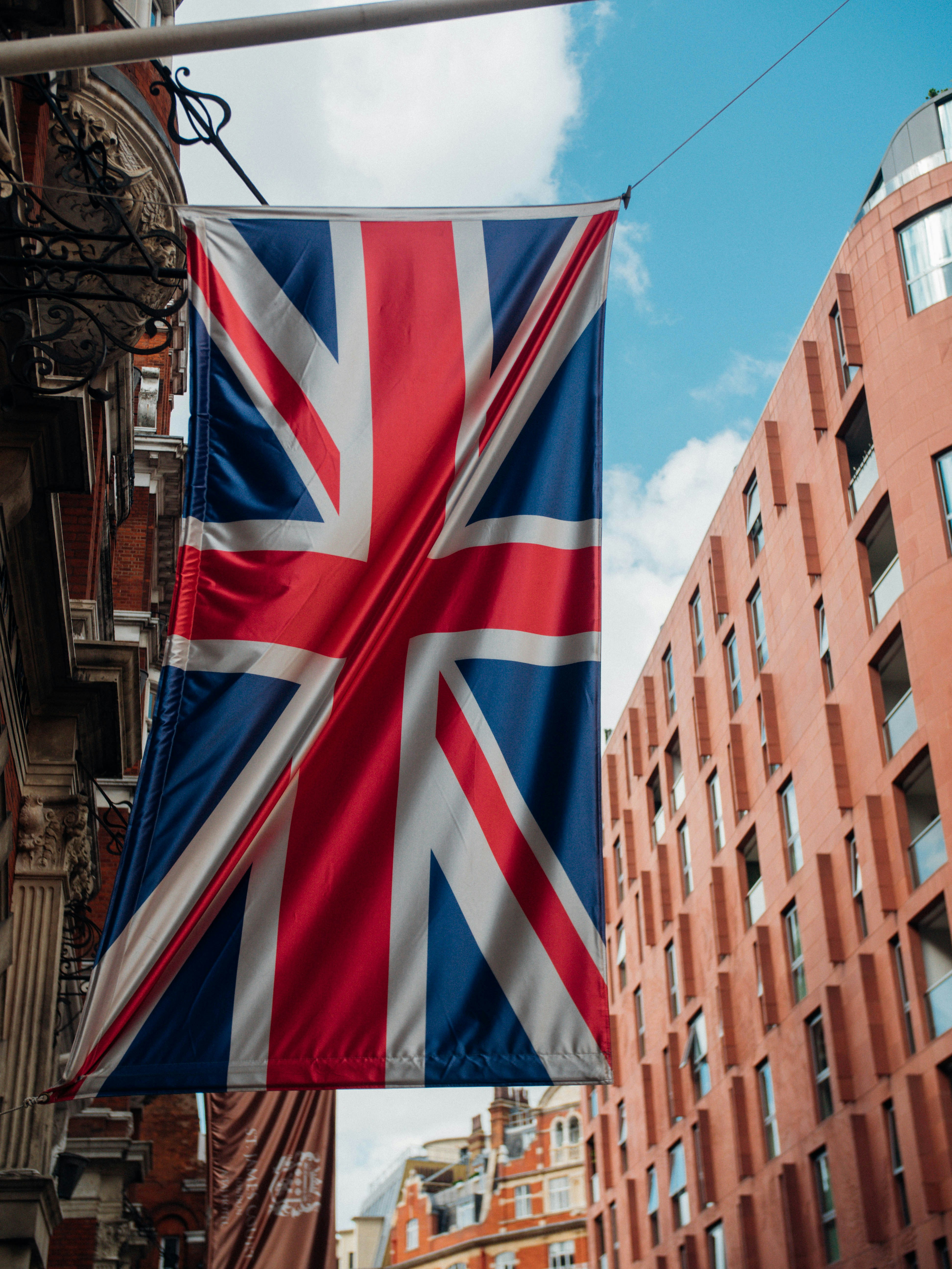Flag in the urban canyon: Union Jack flags hanging between brick and glass
