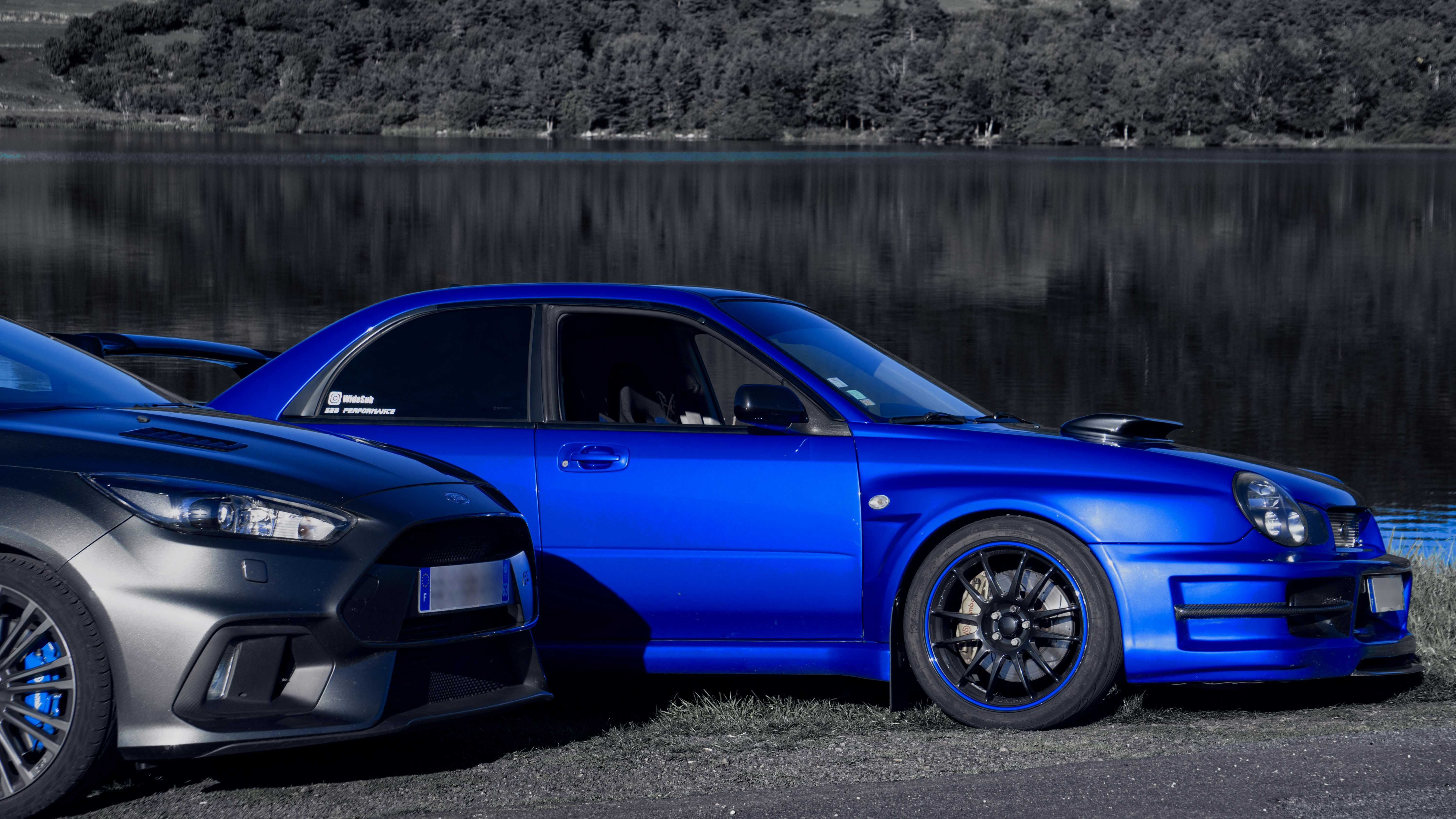 A couple of blue cars parked next to a fence photo – Free Jdm Image on ...