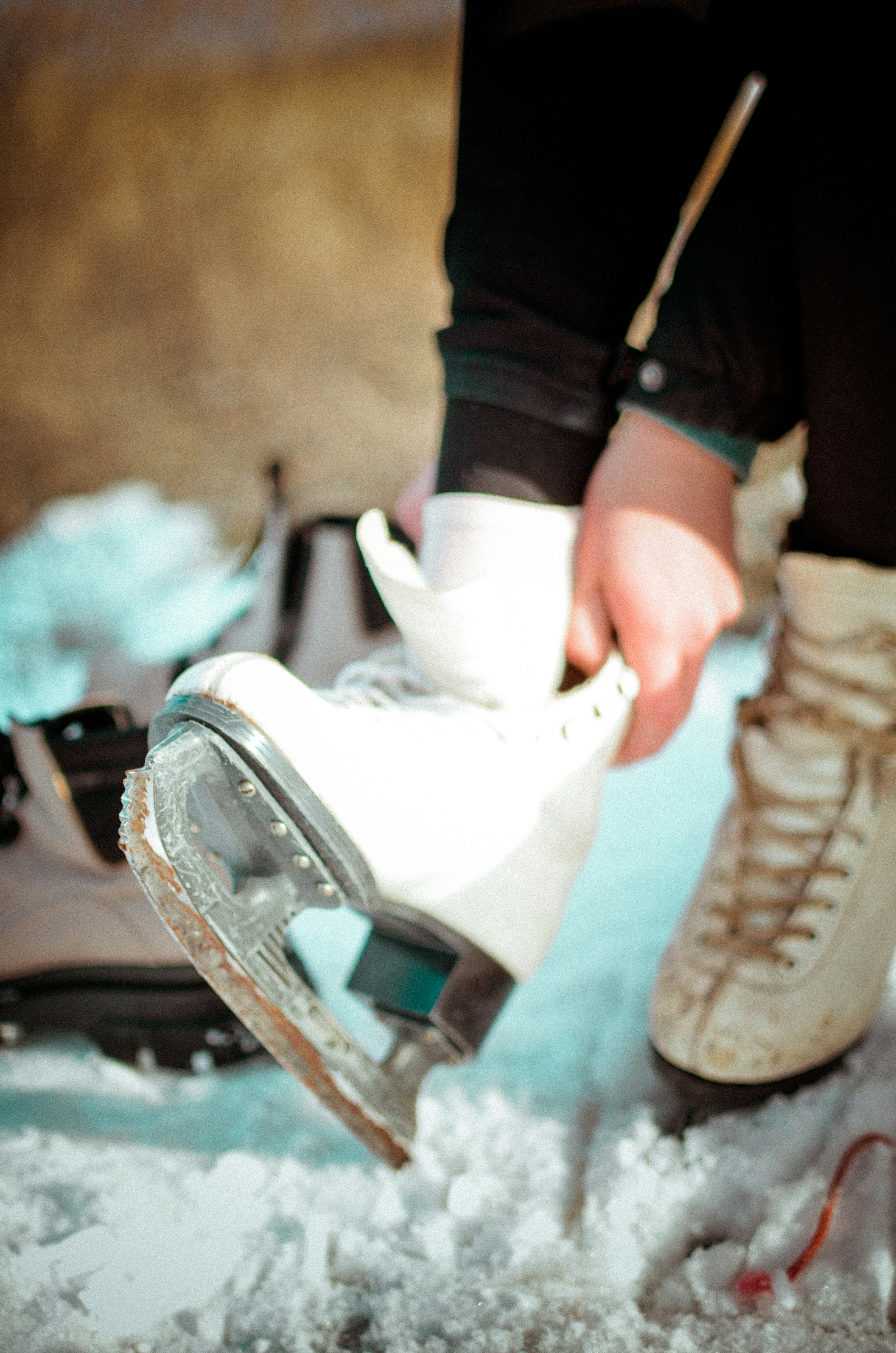 Tying the Edge: A Close-Up of White Ice Skates on Snow