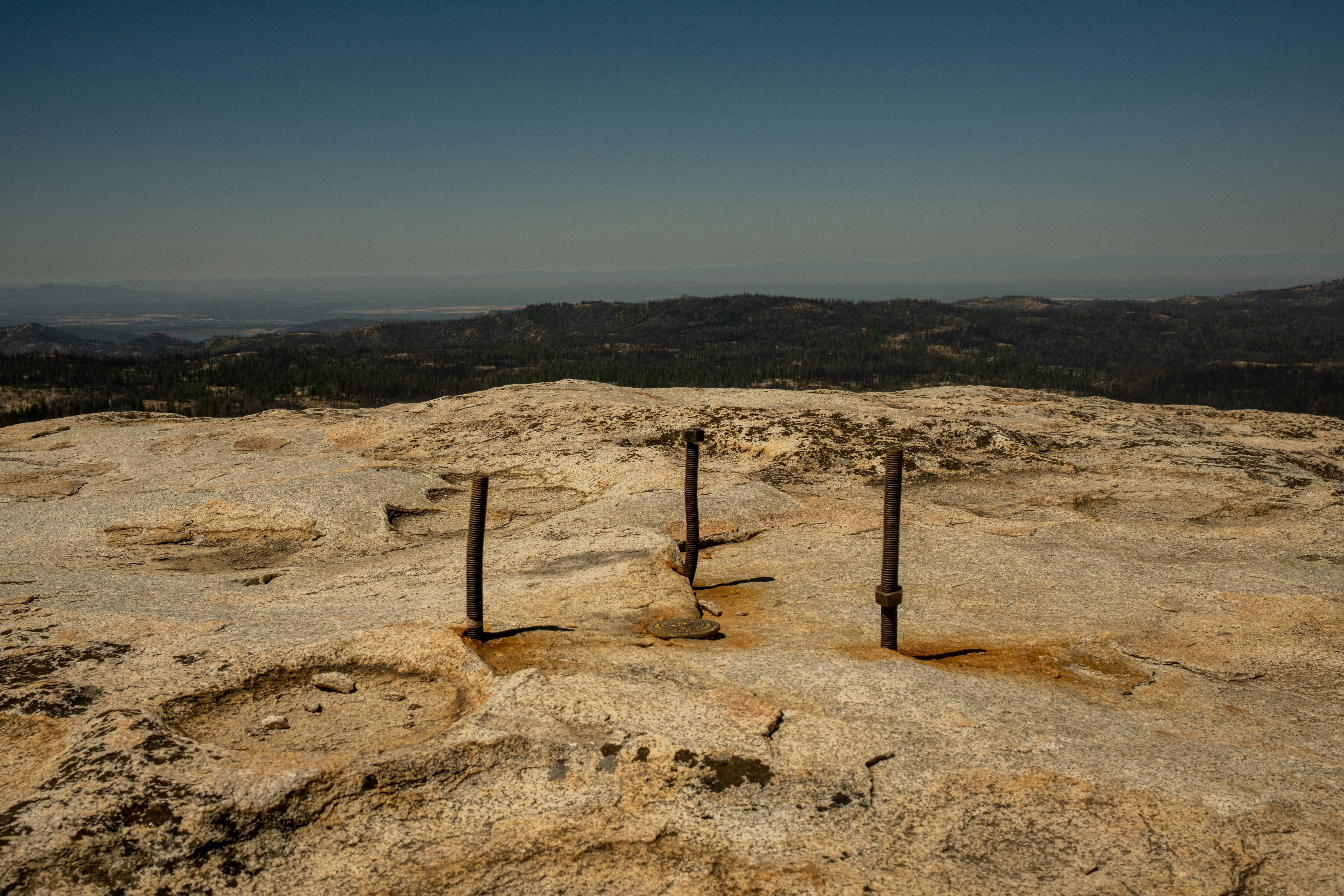 Desert Ridge with Weathered Fence Posts under a Pale Horizon