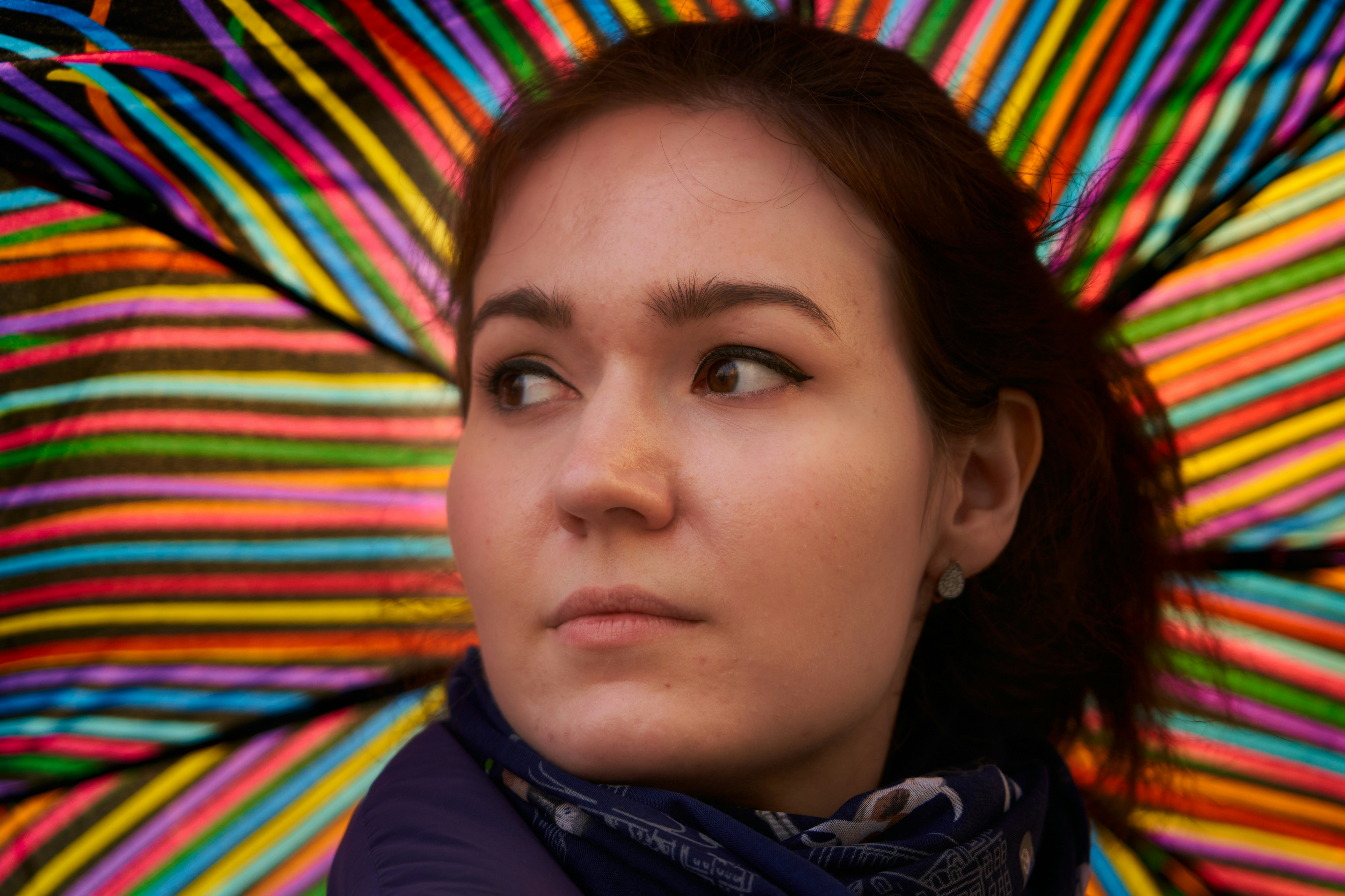 Portrait in Colorful Spokes: A Quiet Gaze Beneath Radiant Stripes