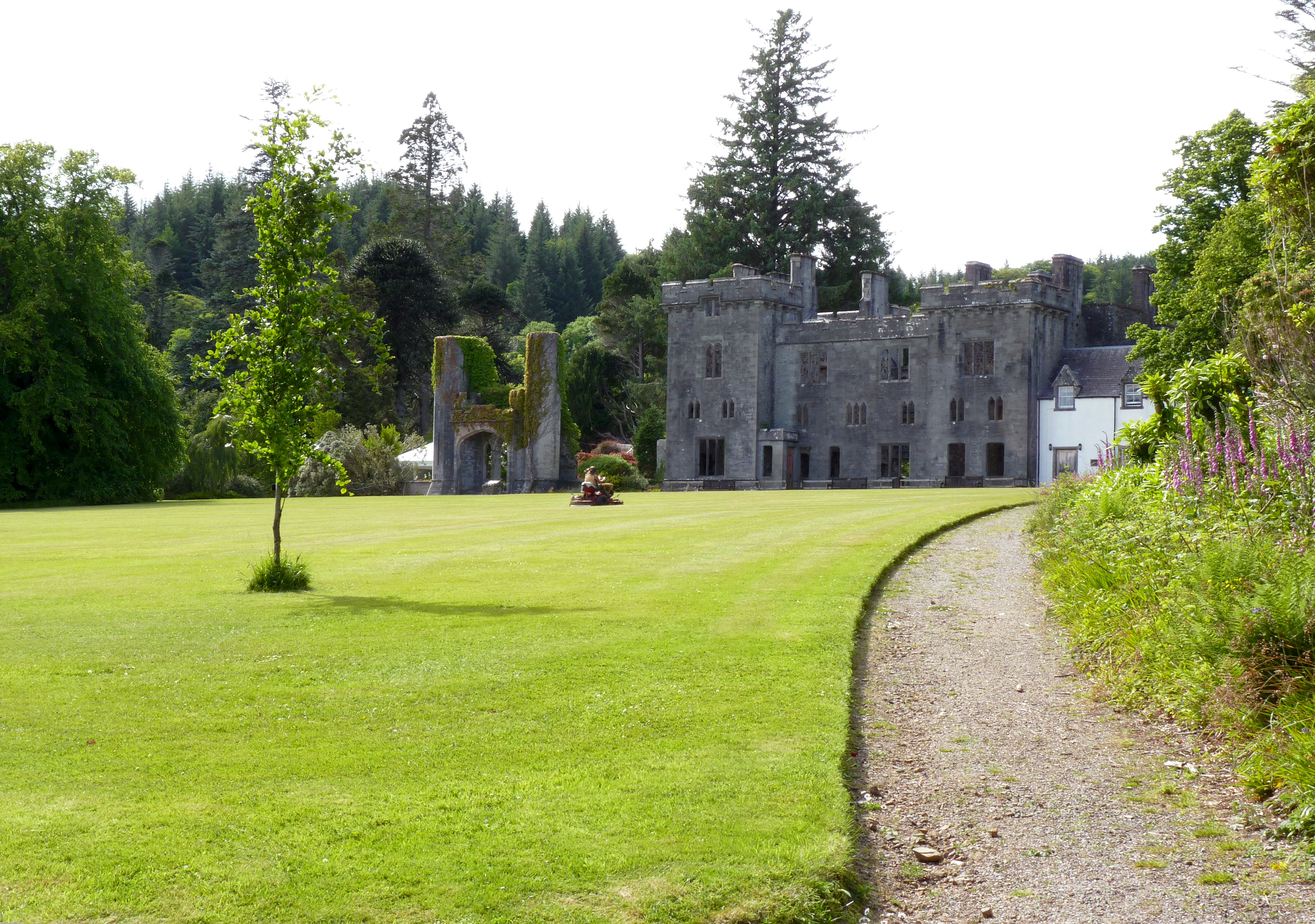A large stone building with a grass lawn and trees photo – Free Isle of ...