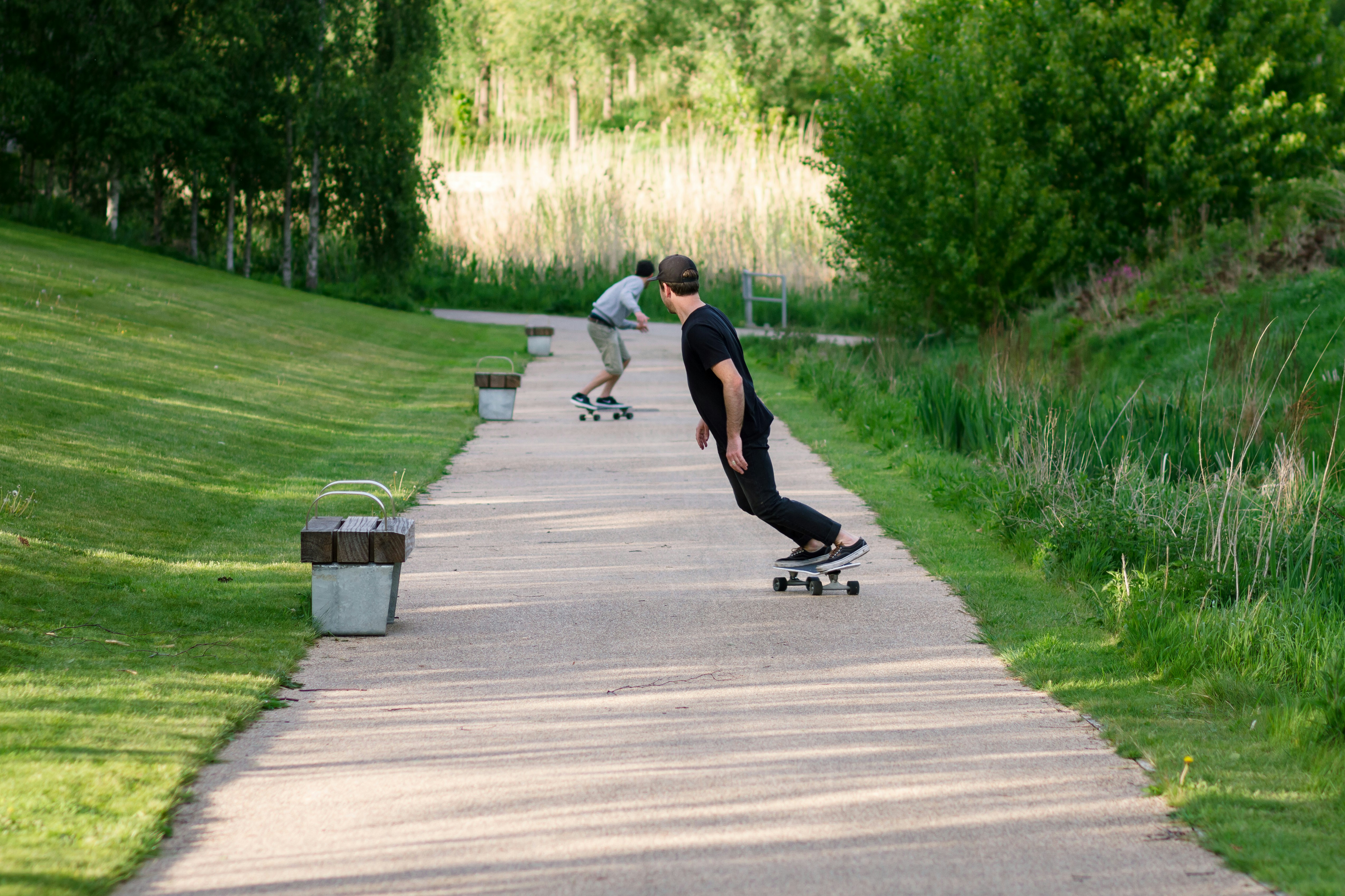 A young man riding a skateboard up the side of a road photo – Free City ...