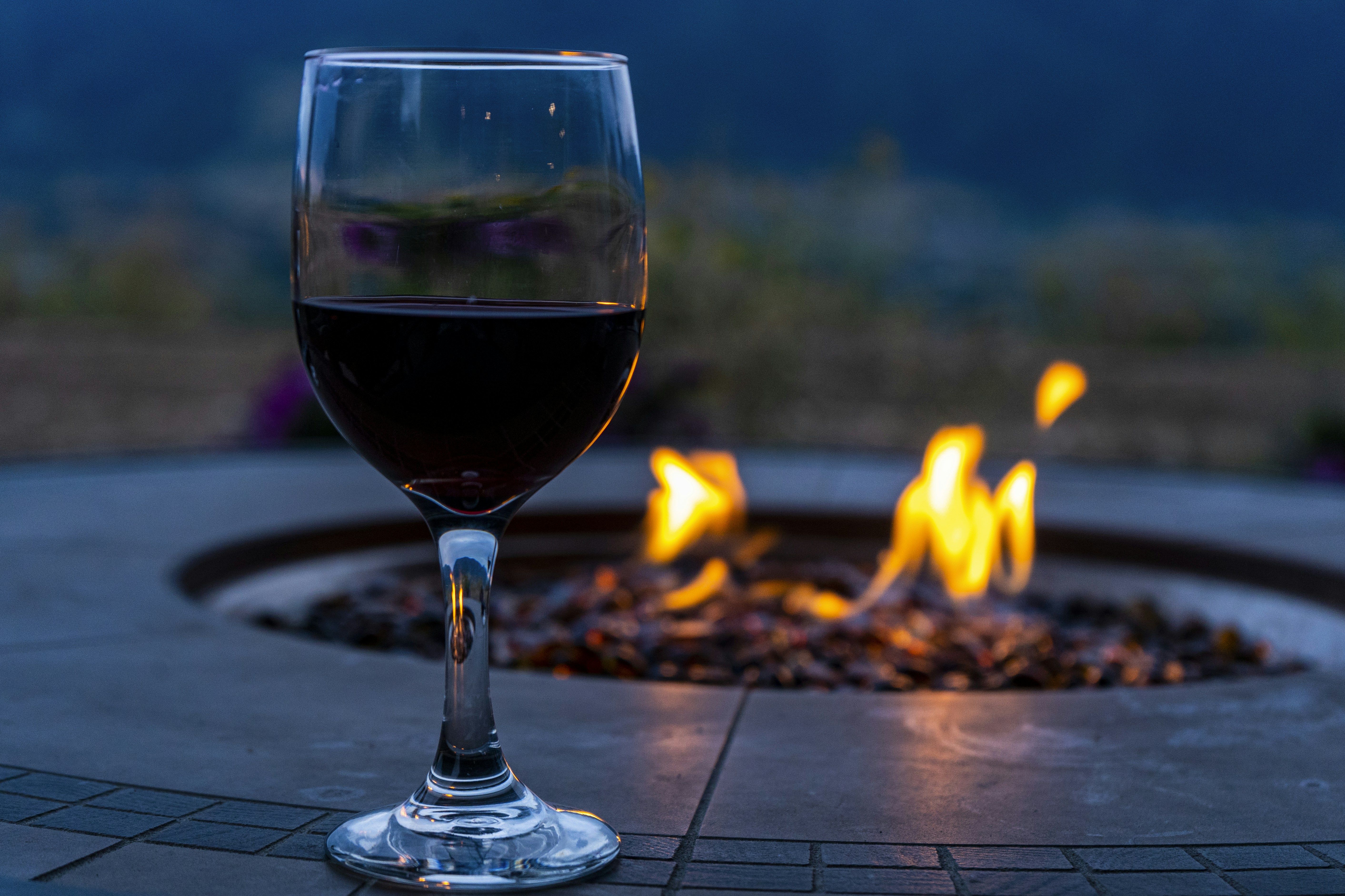 A glass of red wine on a table with fire and flames photo – Free ...