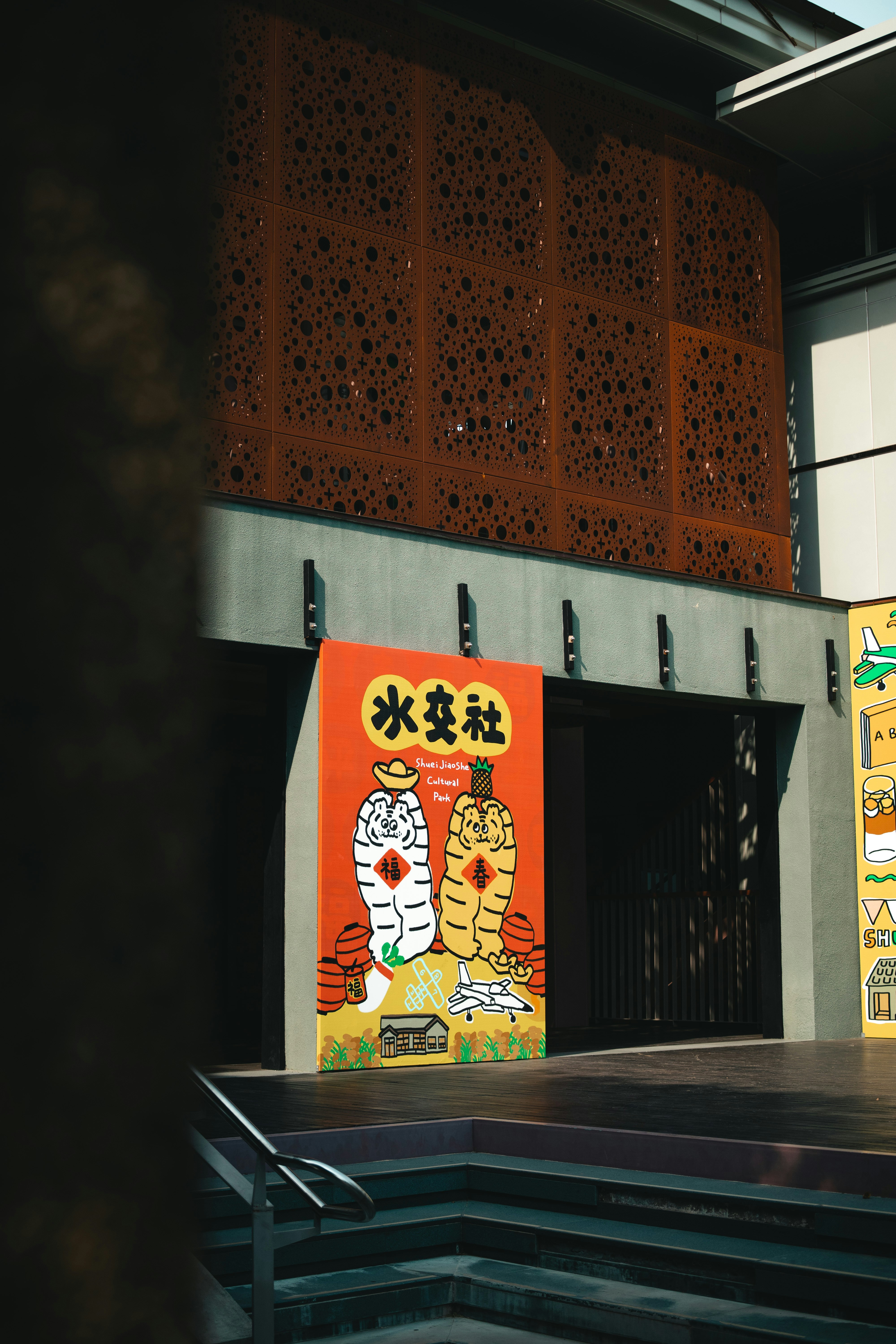 Two Cartoon Cats Guard the Orange Panel at a Street-Facing Entrance