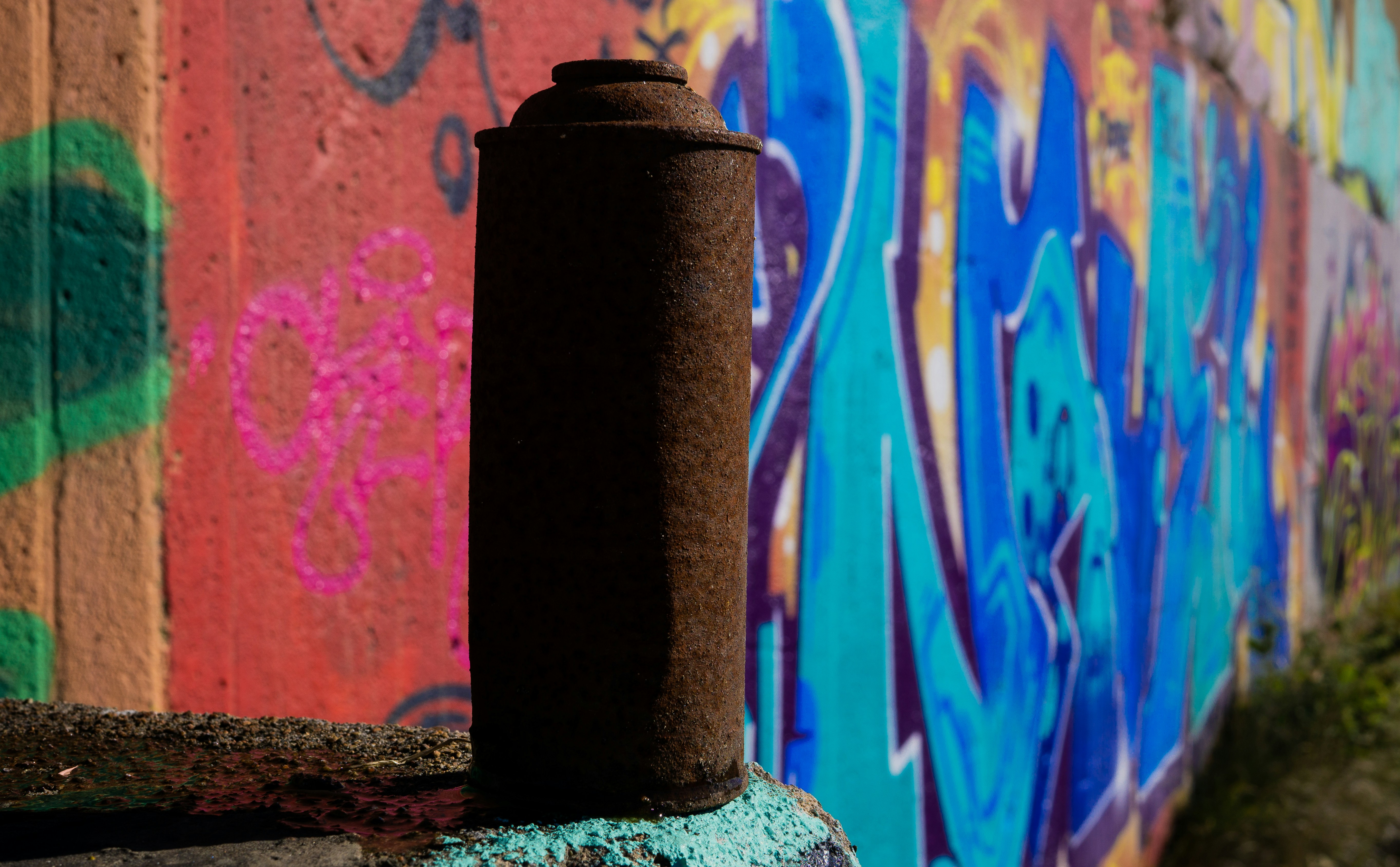 Rusty Spray Can Anchors a Neon Graffiti Wall