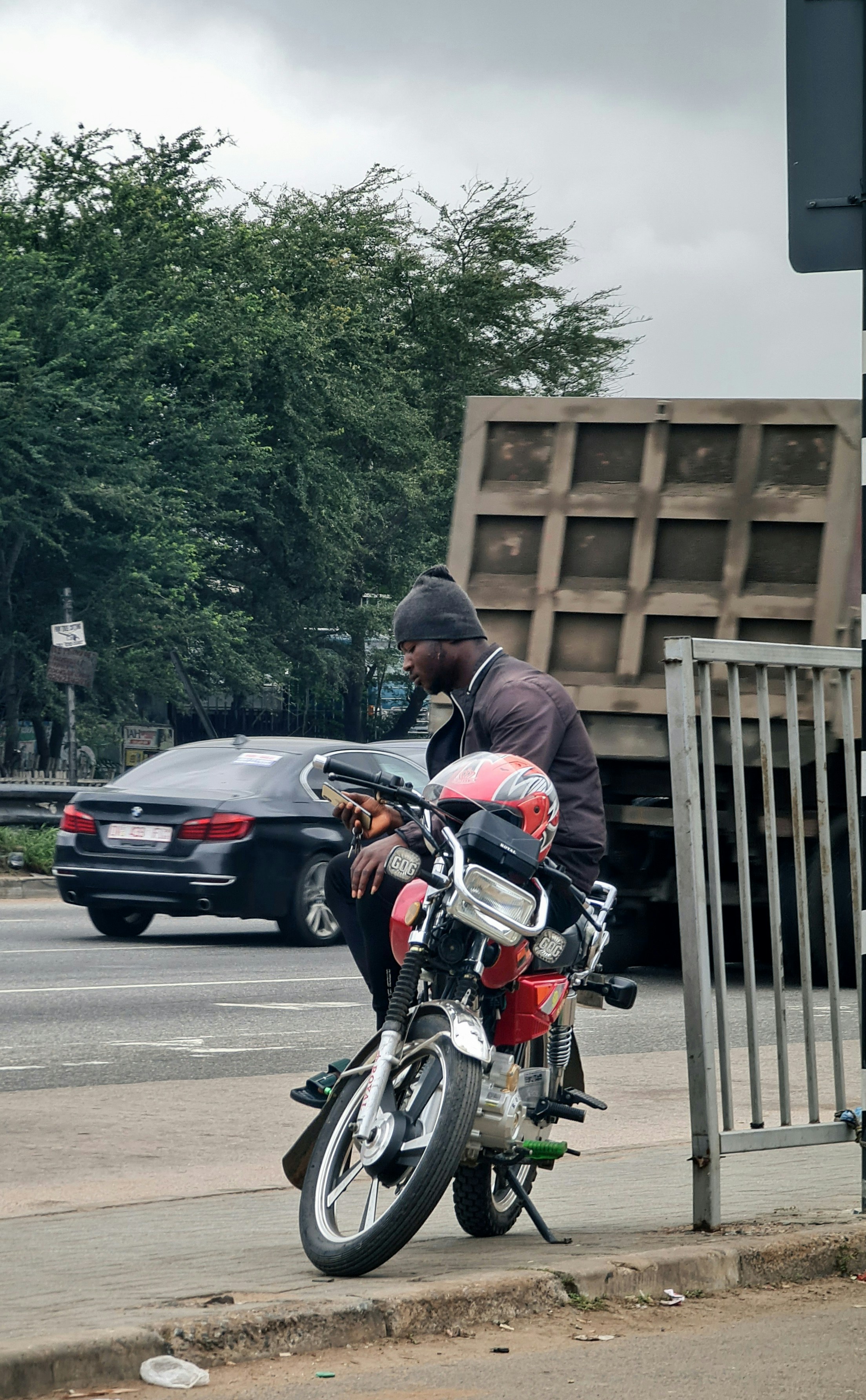 Red Motorcycle at the Curb: A Quiet Moment Amid Urban Machinery