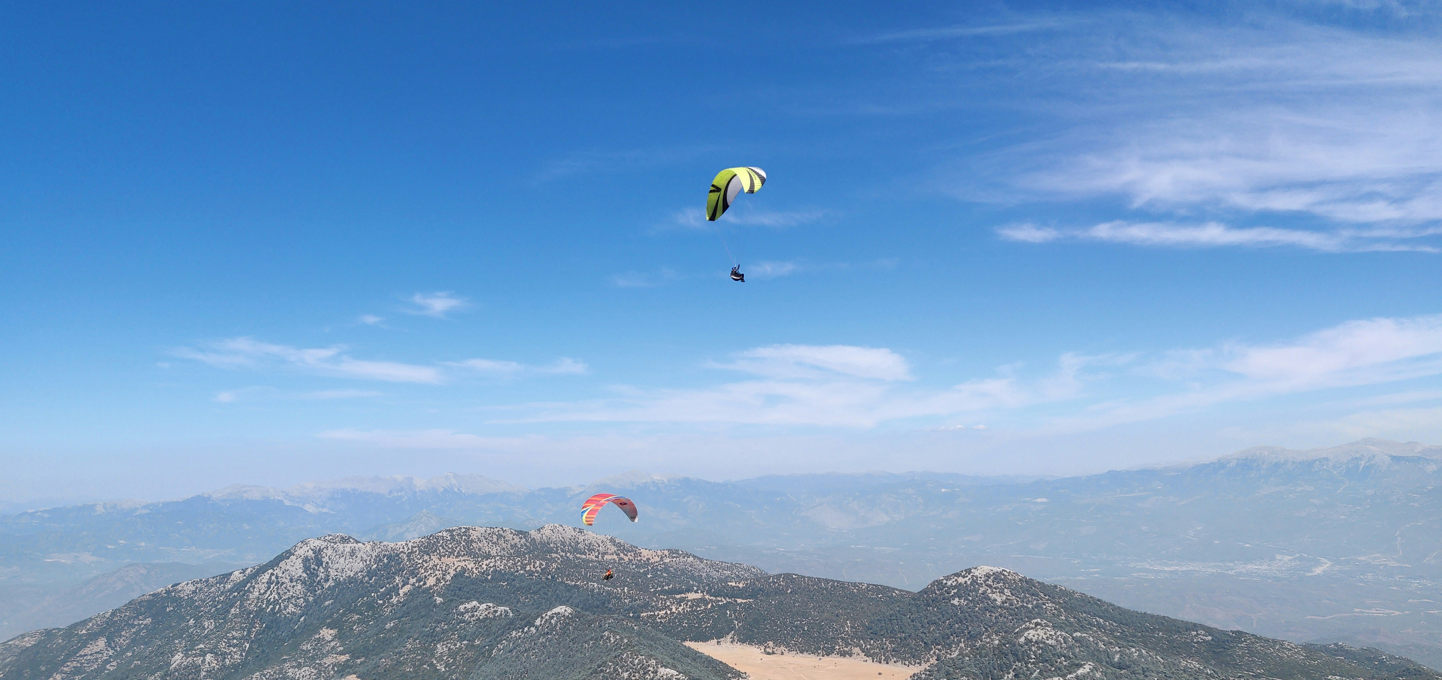 Yellow Paraglider Anchors the Sky Over a Rugged Alpine Ridge