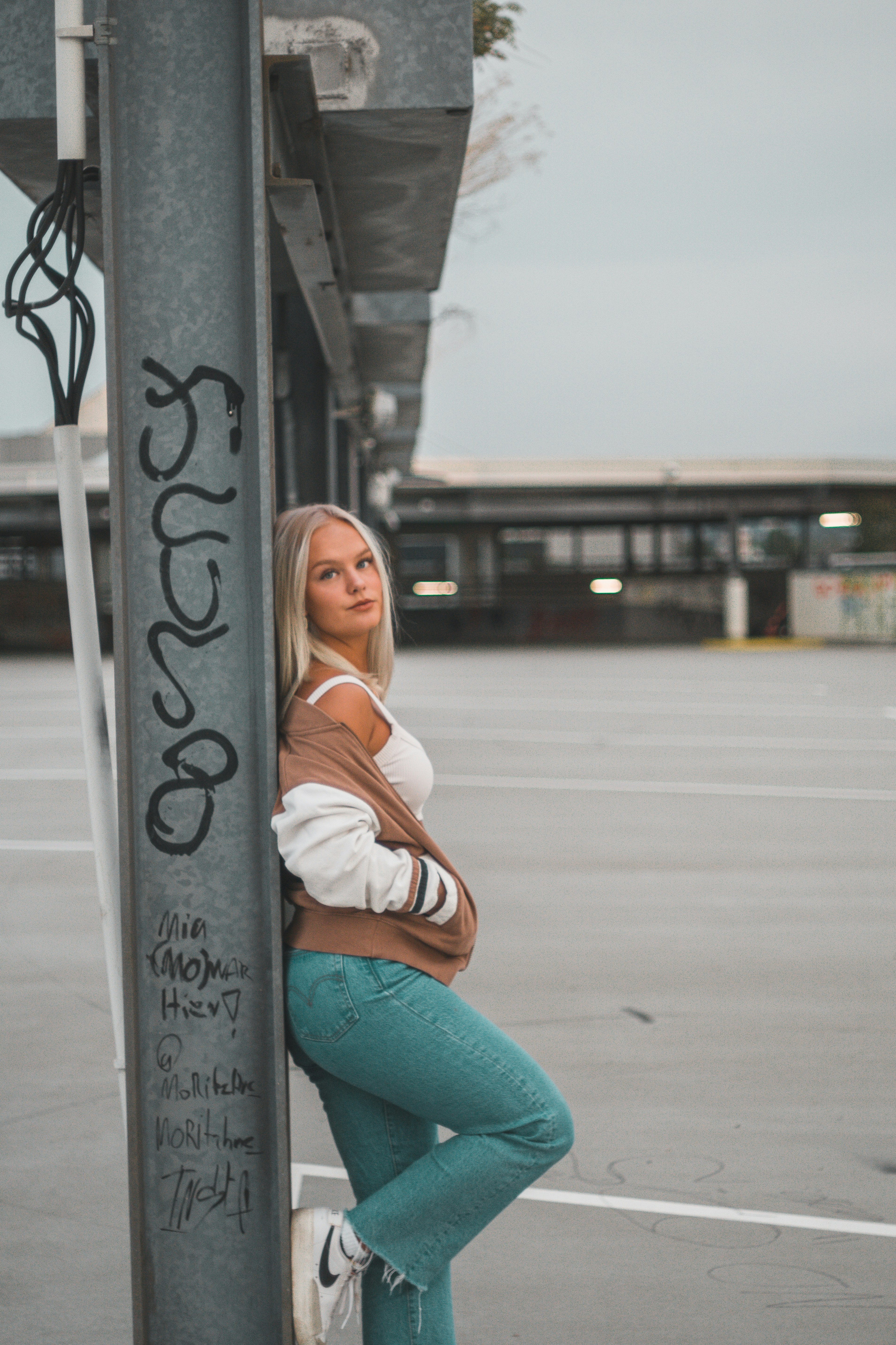A woman leaning against a pole photo – Free Woman Image on Unsplash