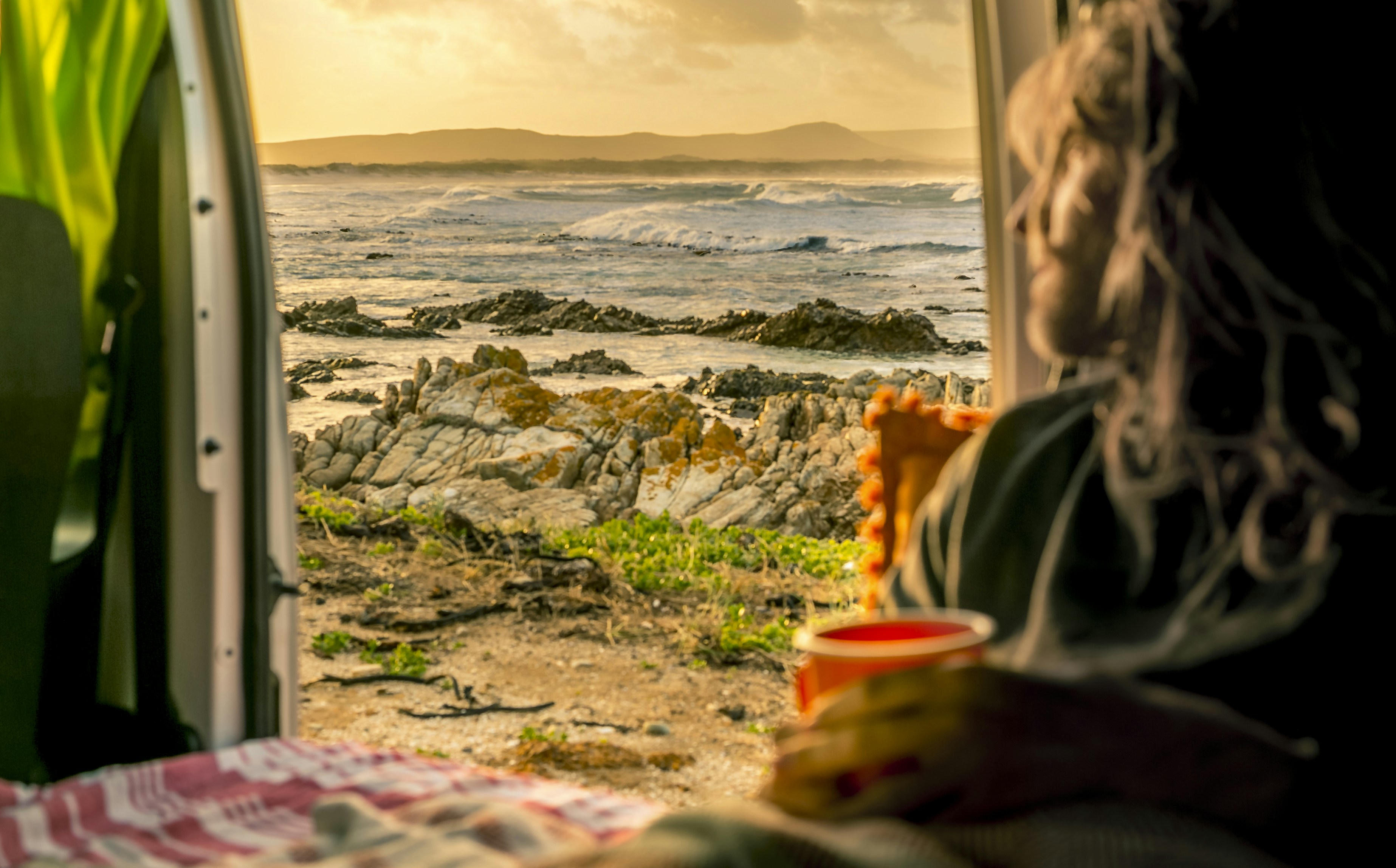 Golden Threshold: Dusk Coast Framed by a Camper Van Window