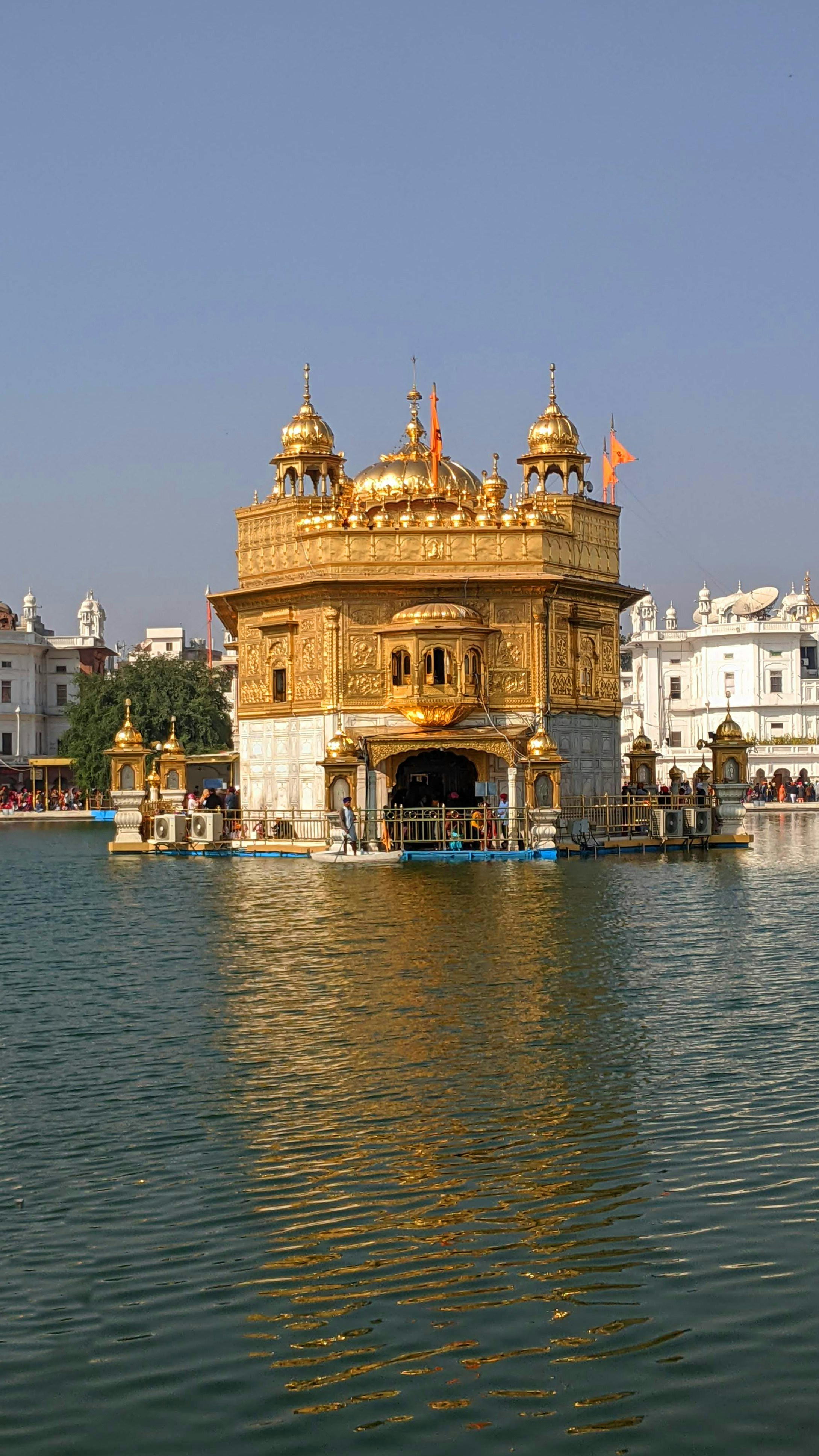 Harmandir Sahib with a gold roof and a gold domed roof surrounded by ...