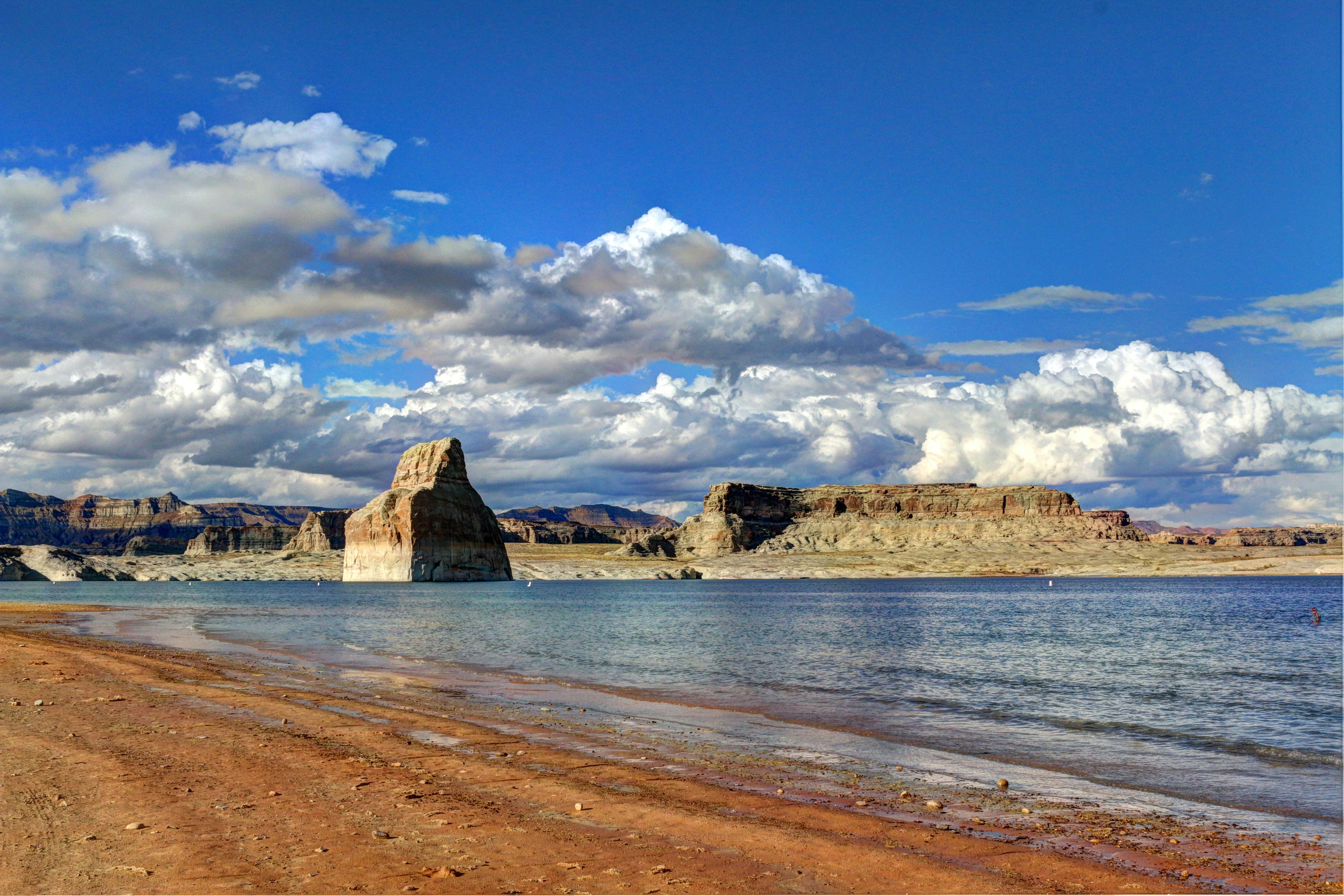 Rock formations rise from the water's edge under a sky filled with dramatic clouds.