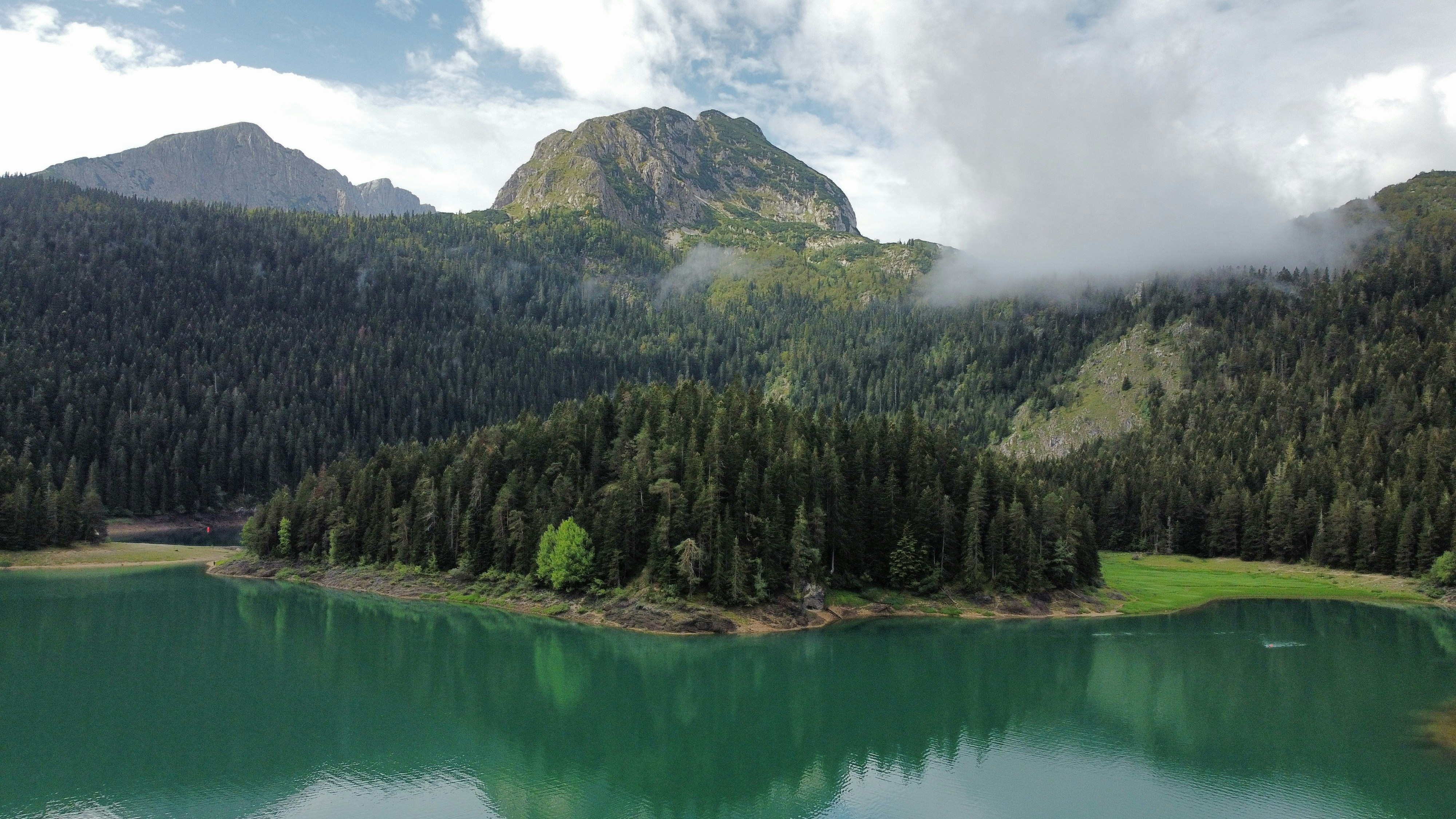 Un lac avec des arbres et des montagnes en arrière-plan photo – Photo ...