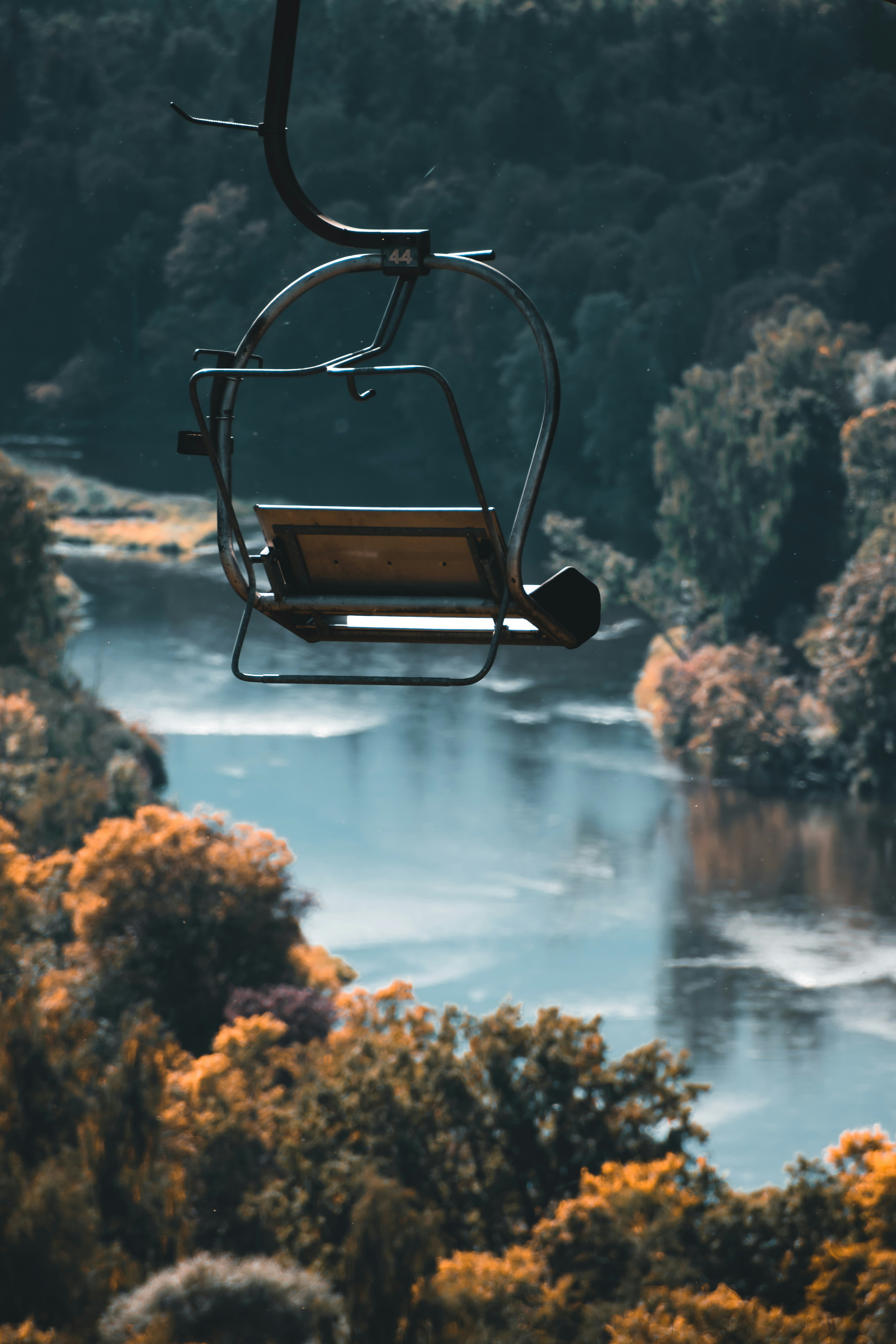 Suspended View: A Chairlift Framing an Autumn River Gorge