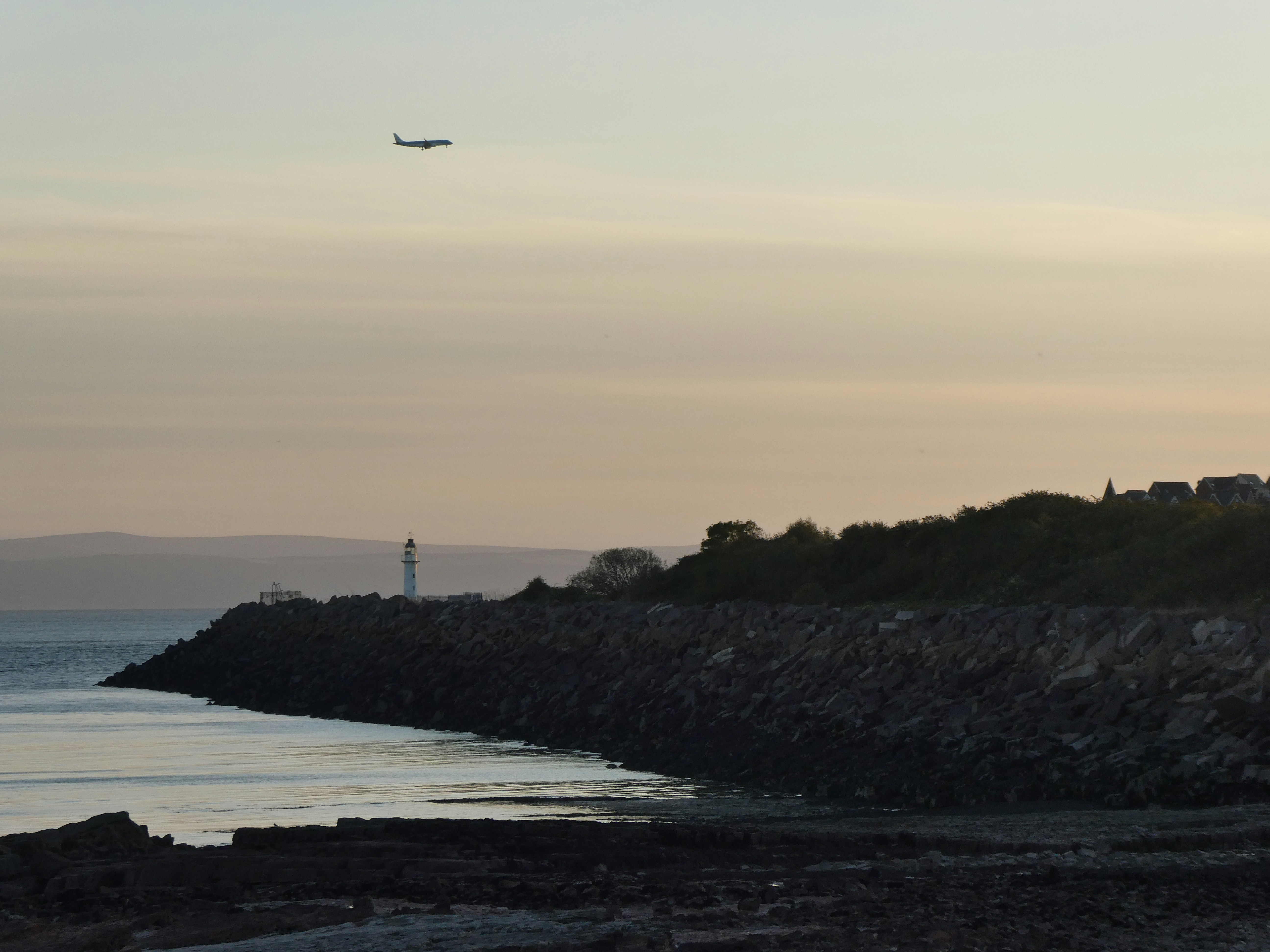 Coastal Beacon: A Quiet Horizon with an Airplane in Transit