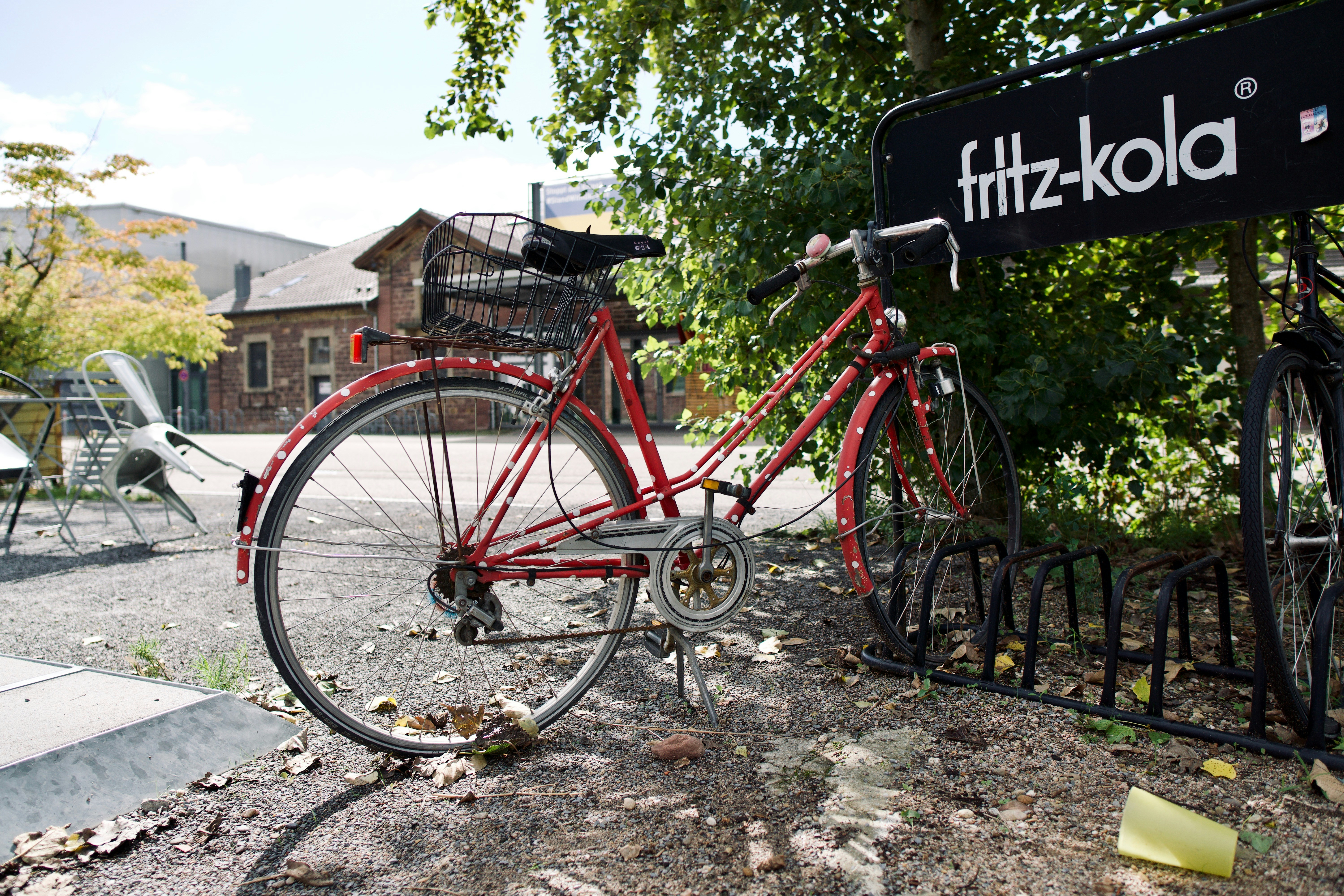 Red Bicycle at a Shade-Dappled Café Lot