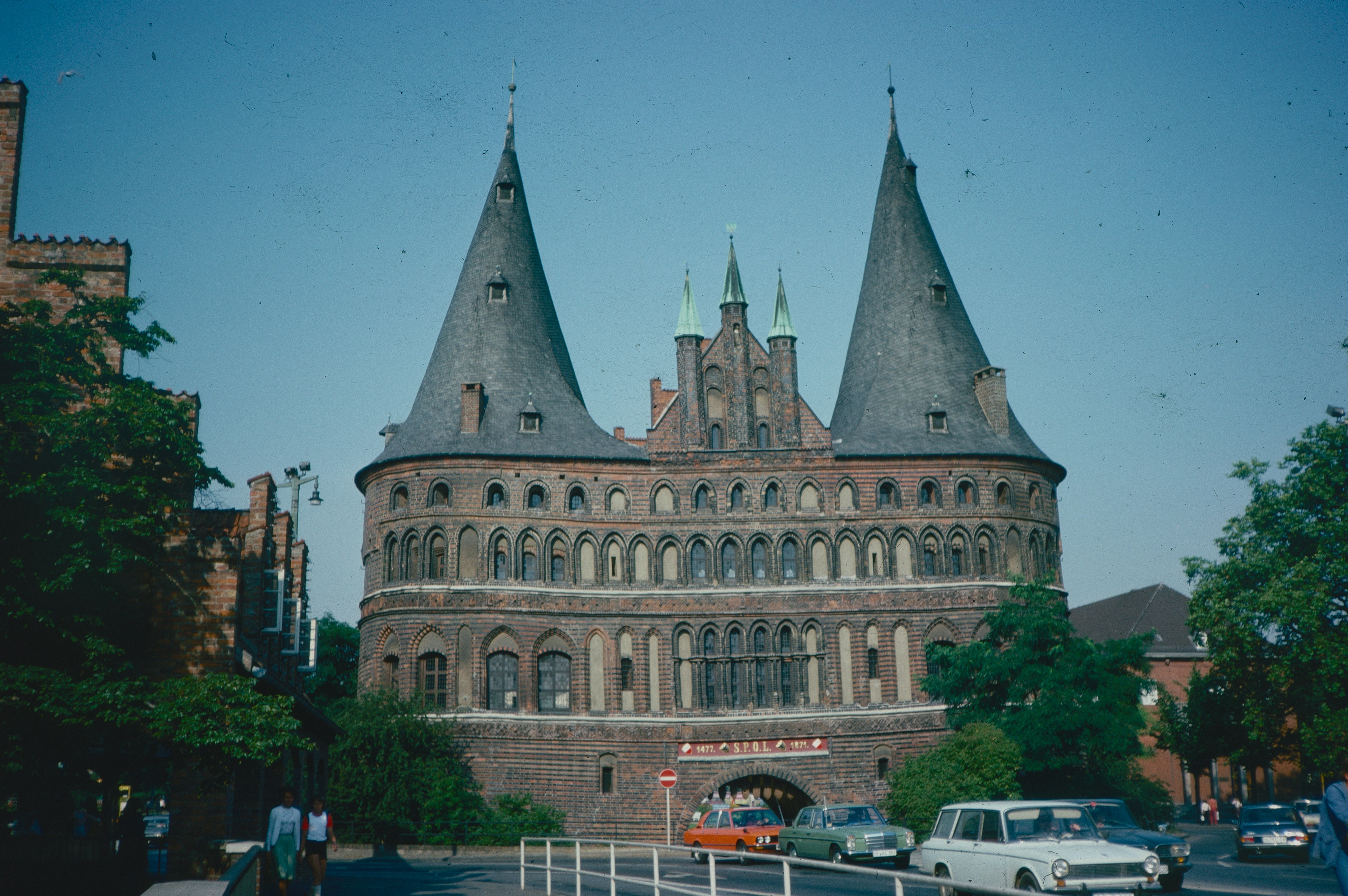 A large building with pointy towers with Holstentor in the background ...
