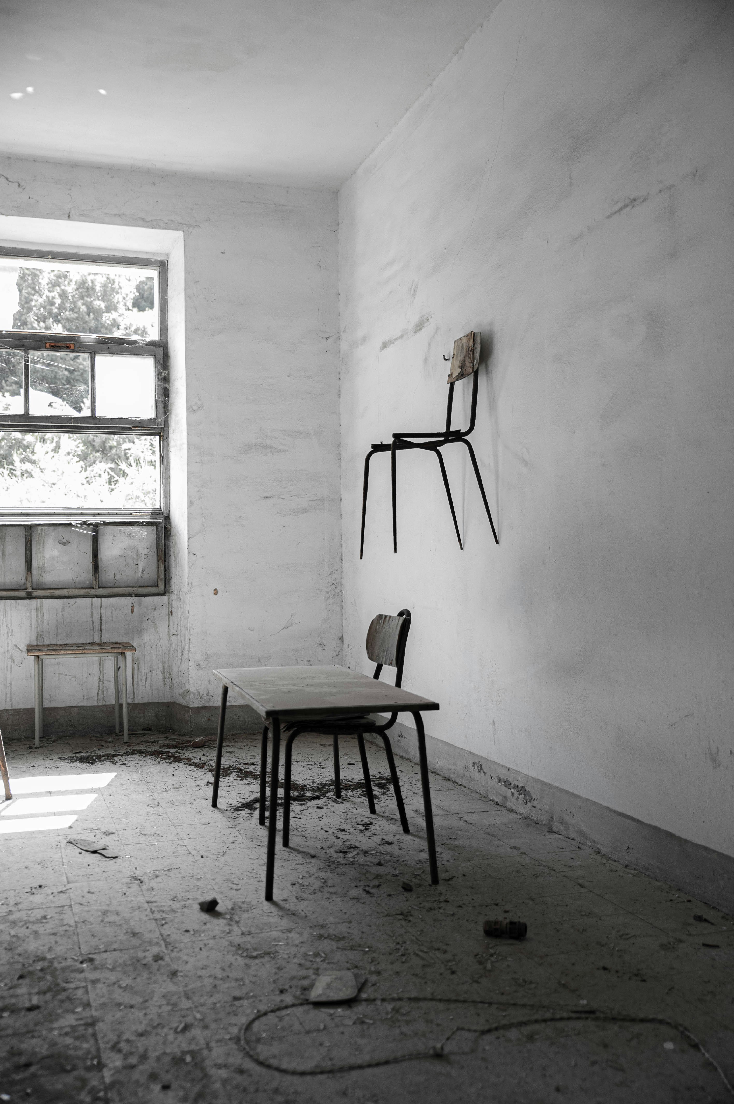 Hushed Geometry: Chairs Adrift on a Bare Wall