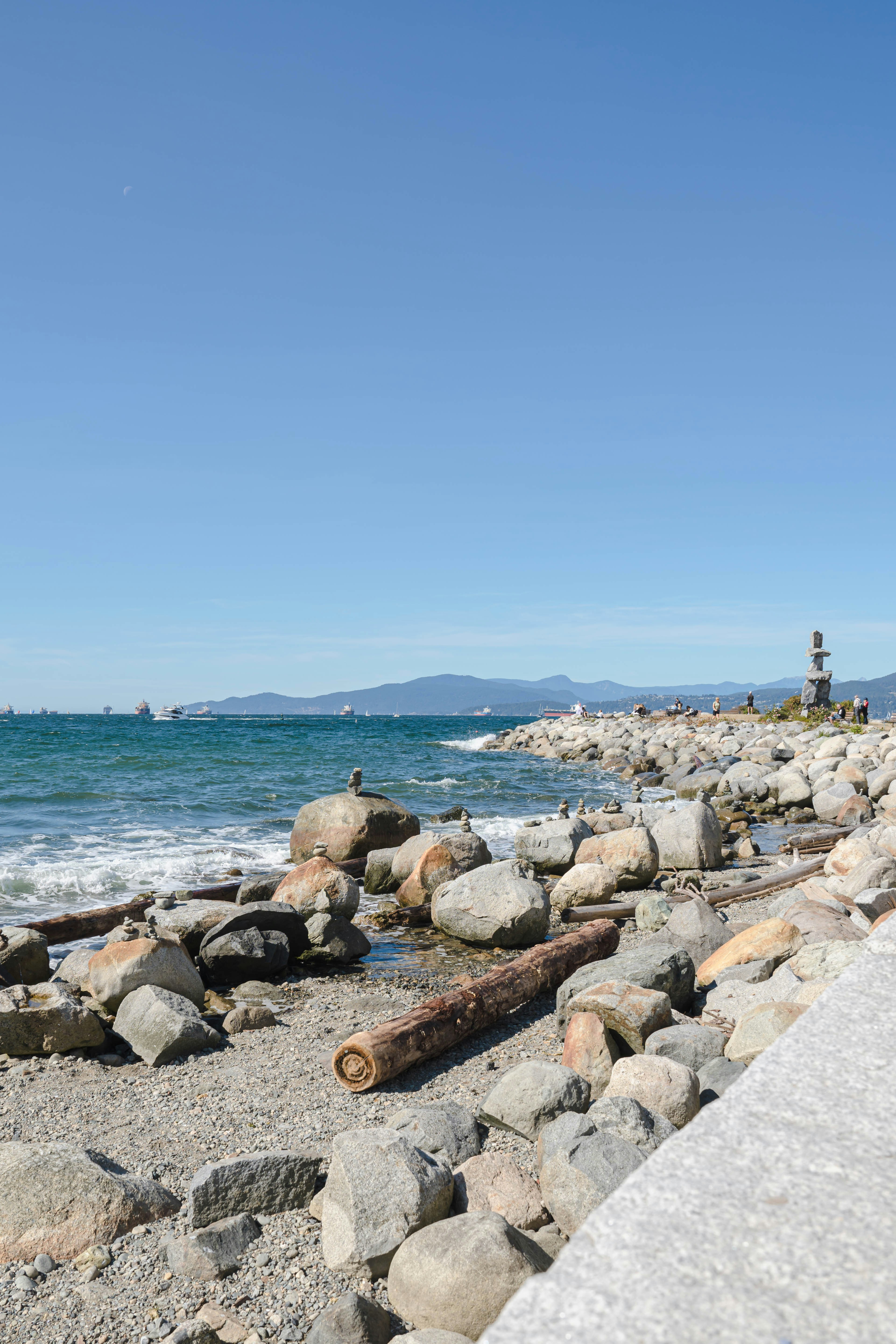 Granite Breakwater: Driftwood and Blue Horizons Along a Pebble Shore