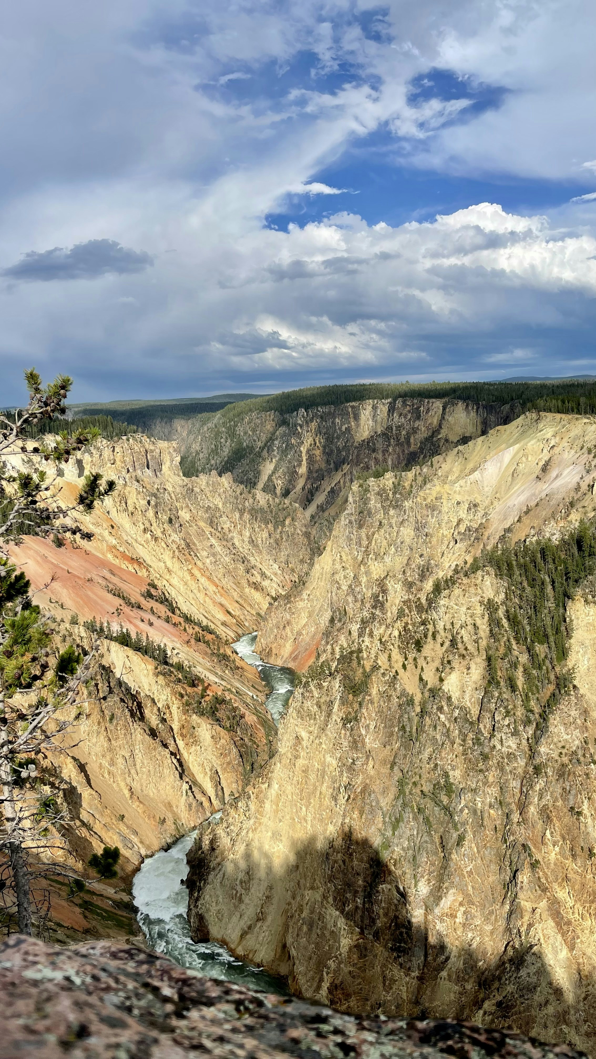 River Ribbon Through a Multicolored Canyon Under a Sky of Layered Clouds