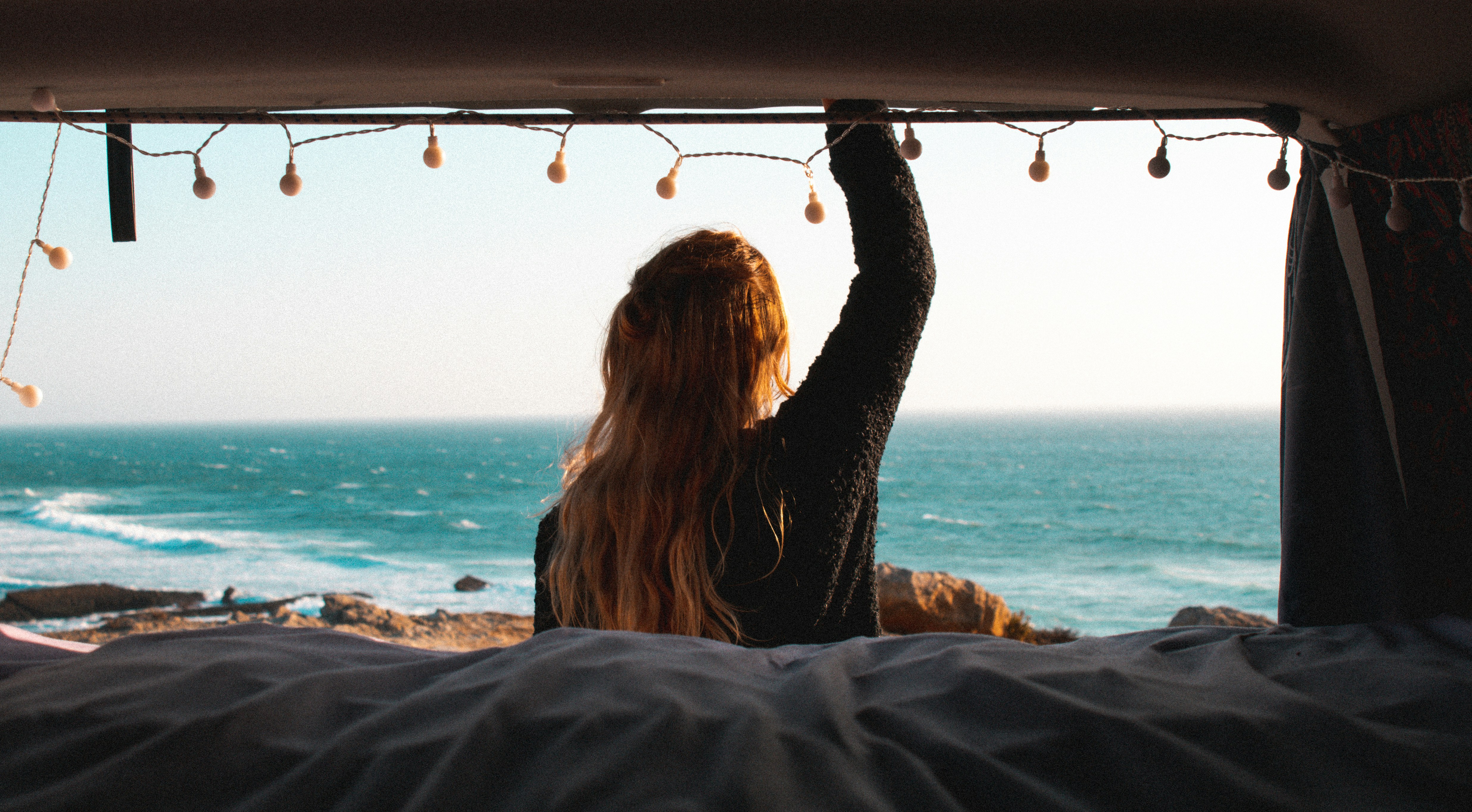 Van-window Reverie: Long-haired silhouette gazing at the sea