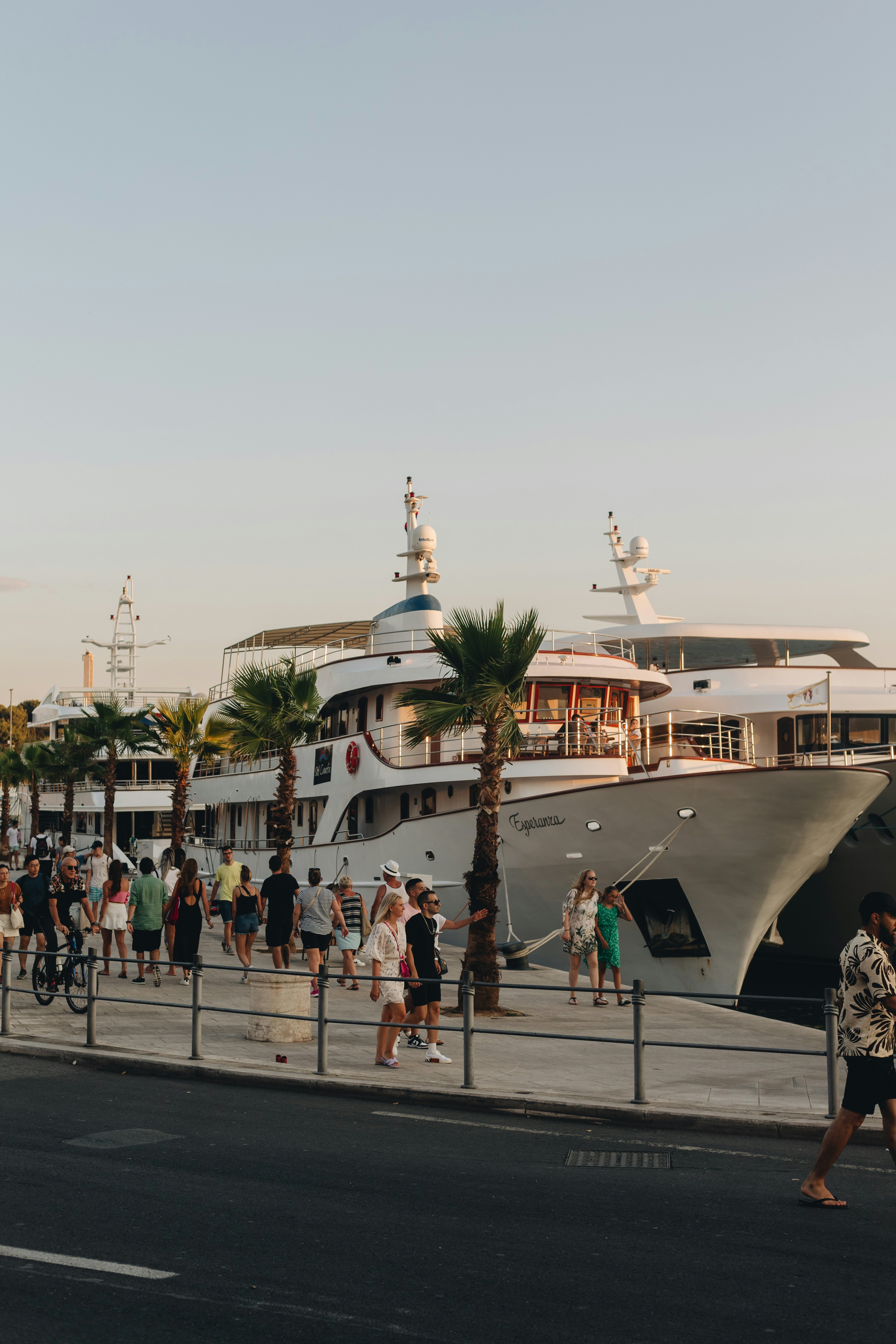 Harbor Parade: Palm-Lined Promenade Framed by a Grand White Yacht at Golden Hour