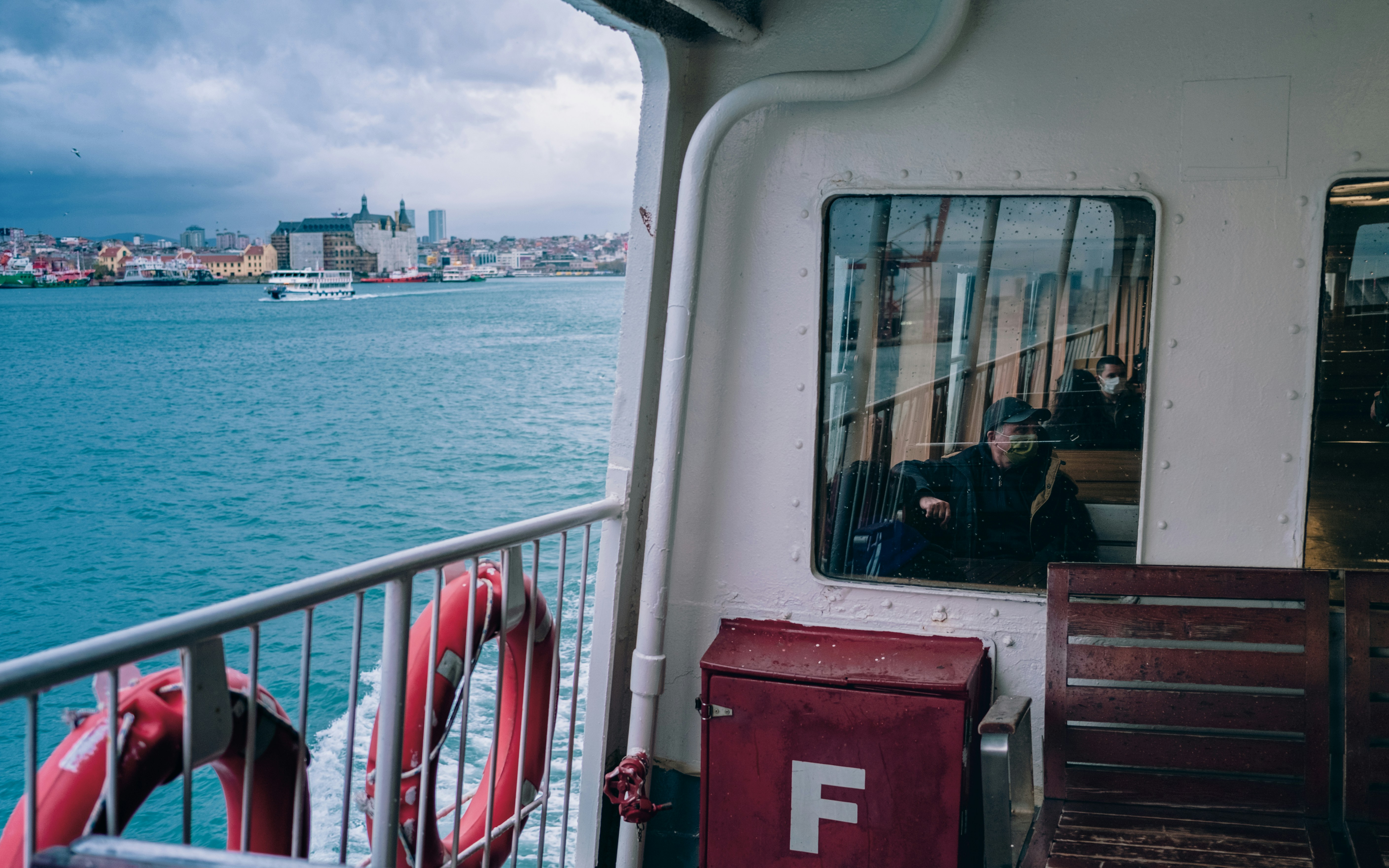 Window Portrait on a Ferry: Cityscape, Sea, and Quiet Cabin Moments