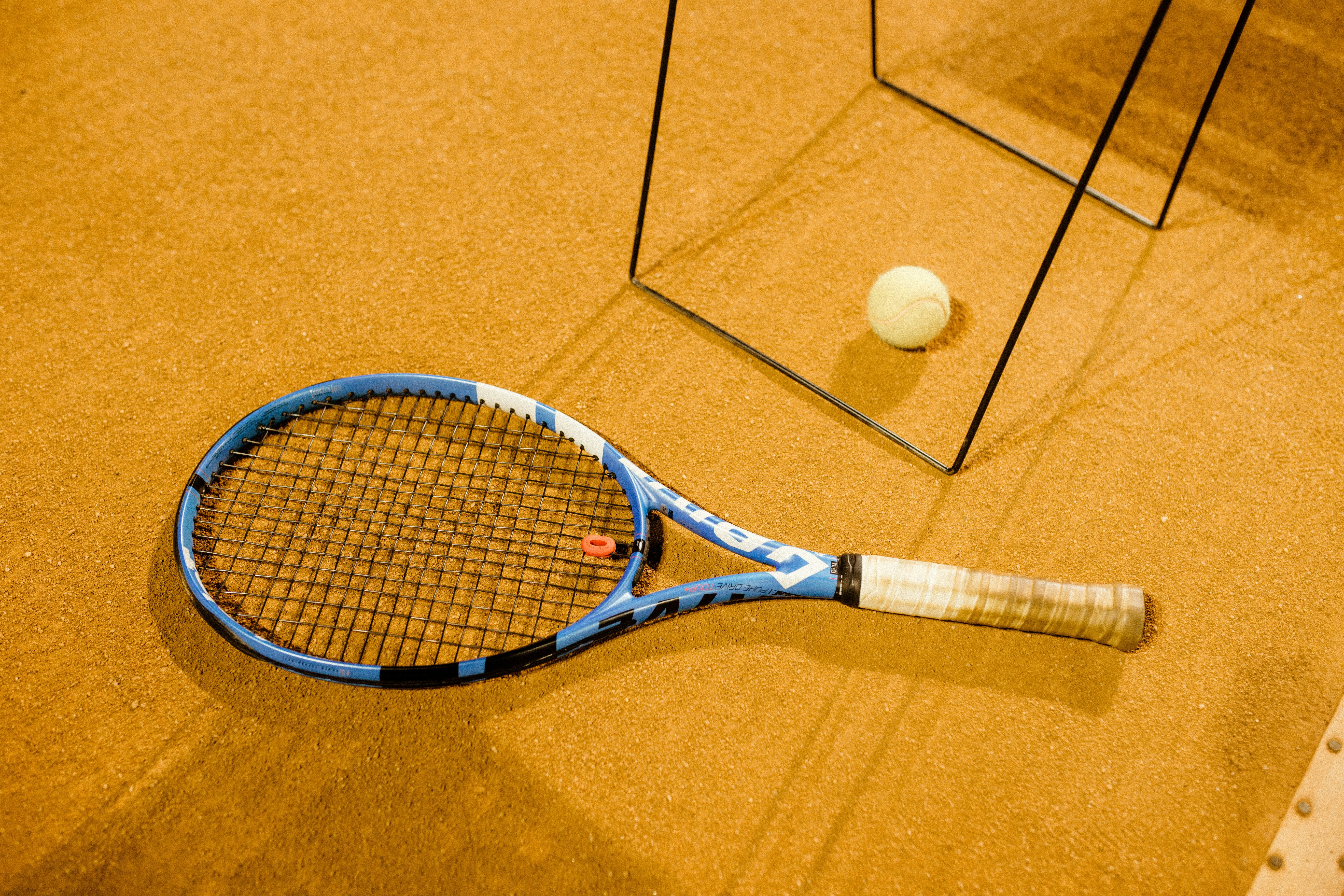 A tennis racket and ball on the ground photo – Free Racket Image on ...