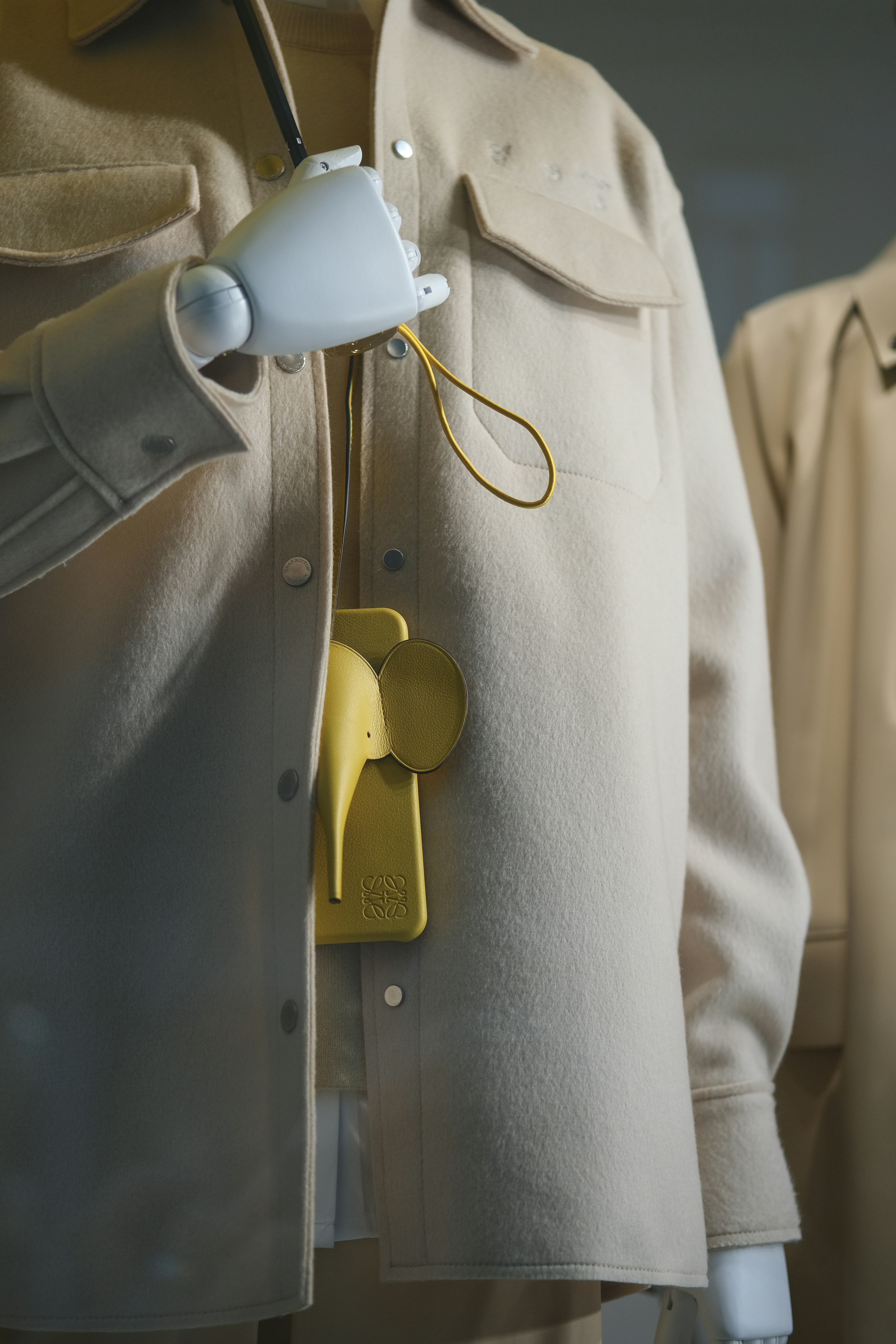 Beige Coat Display with a Bright Yellow Security Tag