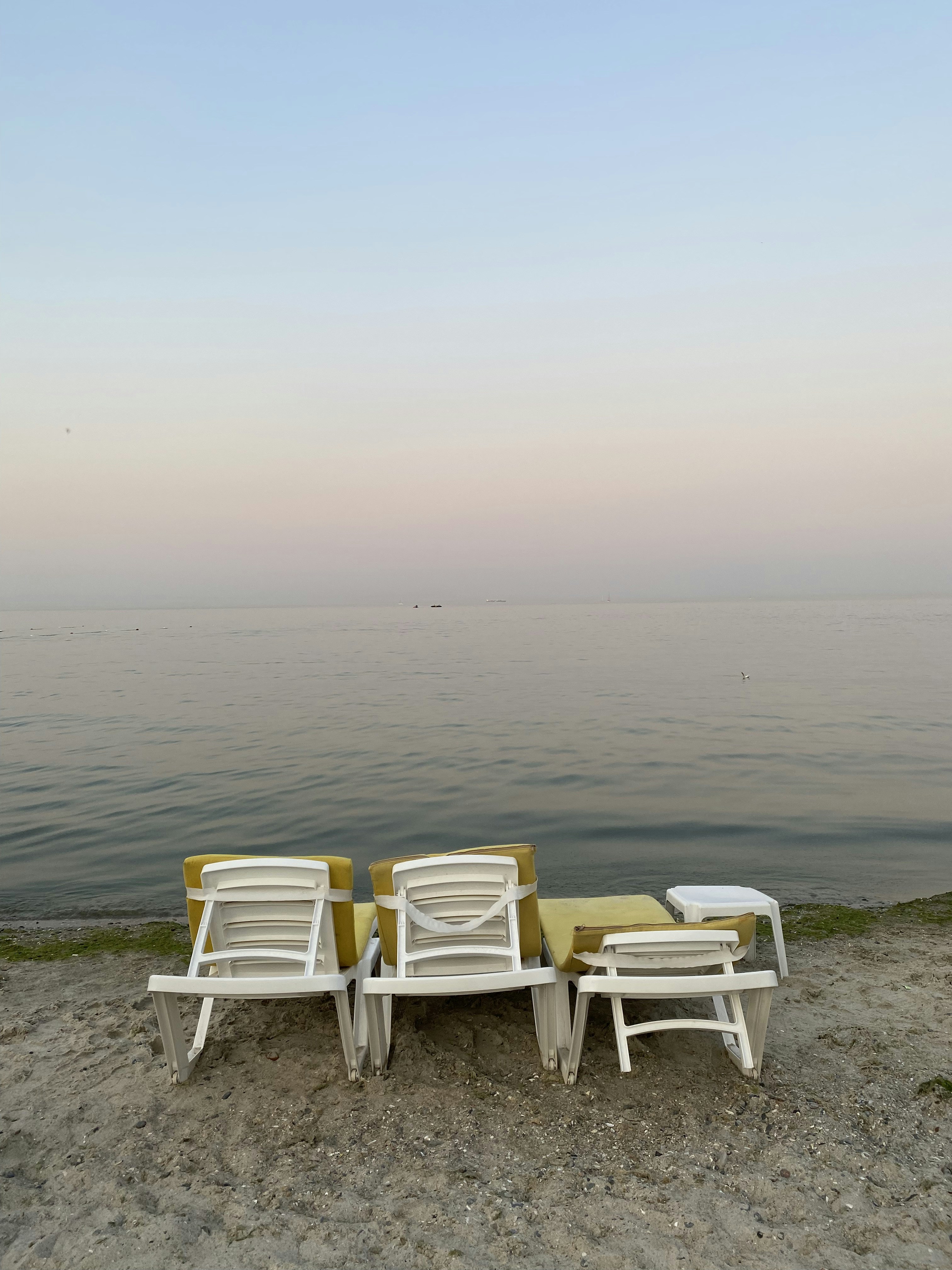 Three loungers and the evening beach landscape | a group of chairs on a beach