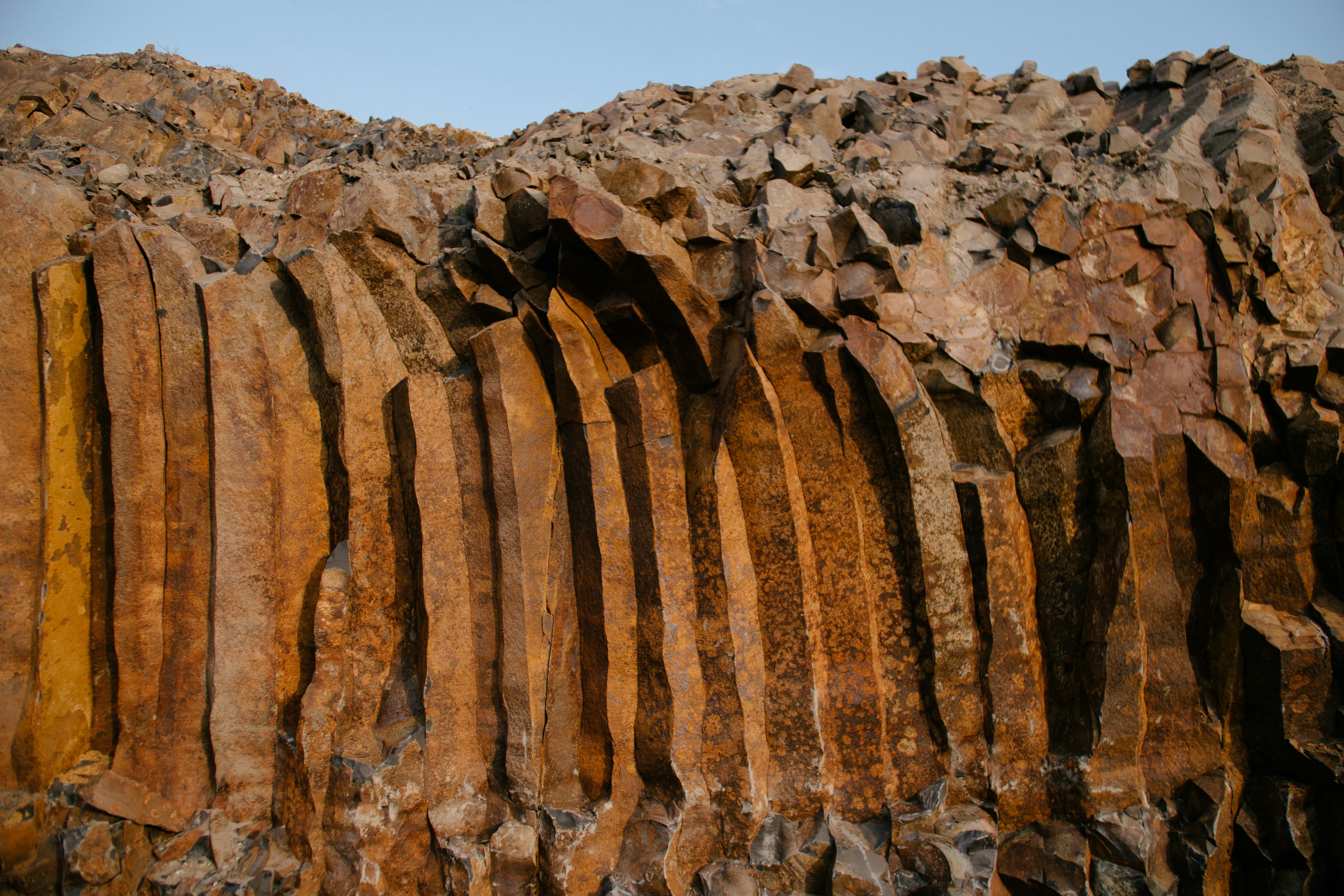 Columnar Giants in Rust: Basalt Pillars Stand Tall Against a Pale Sky