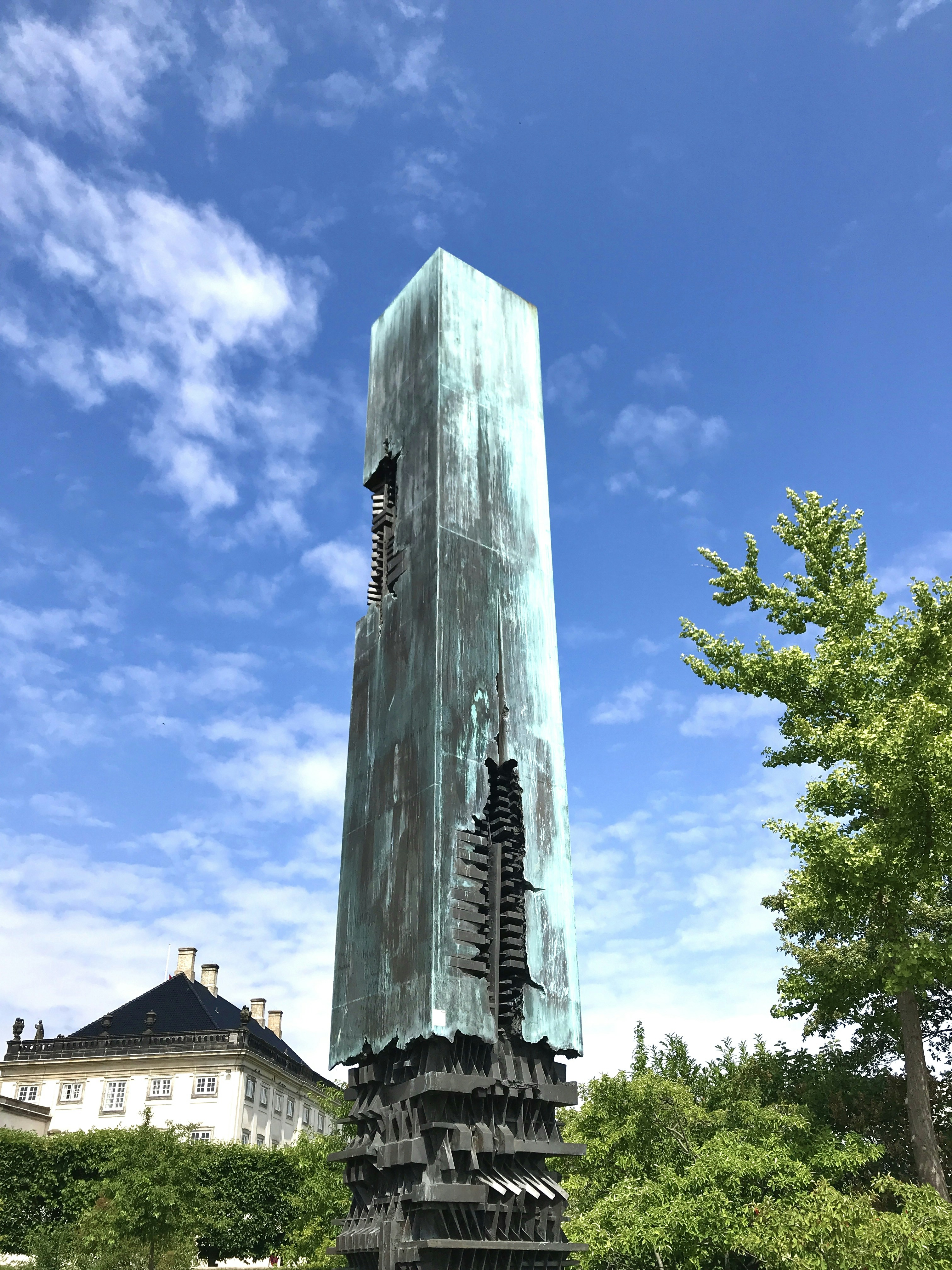 Patina-Tinted Monolith Rising in a Sunlit City Park