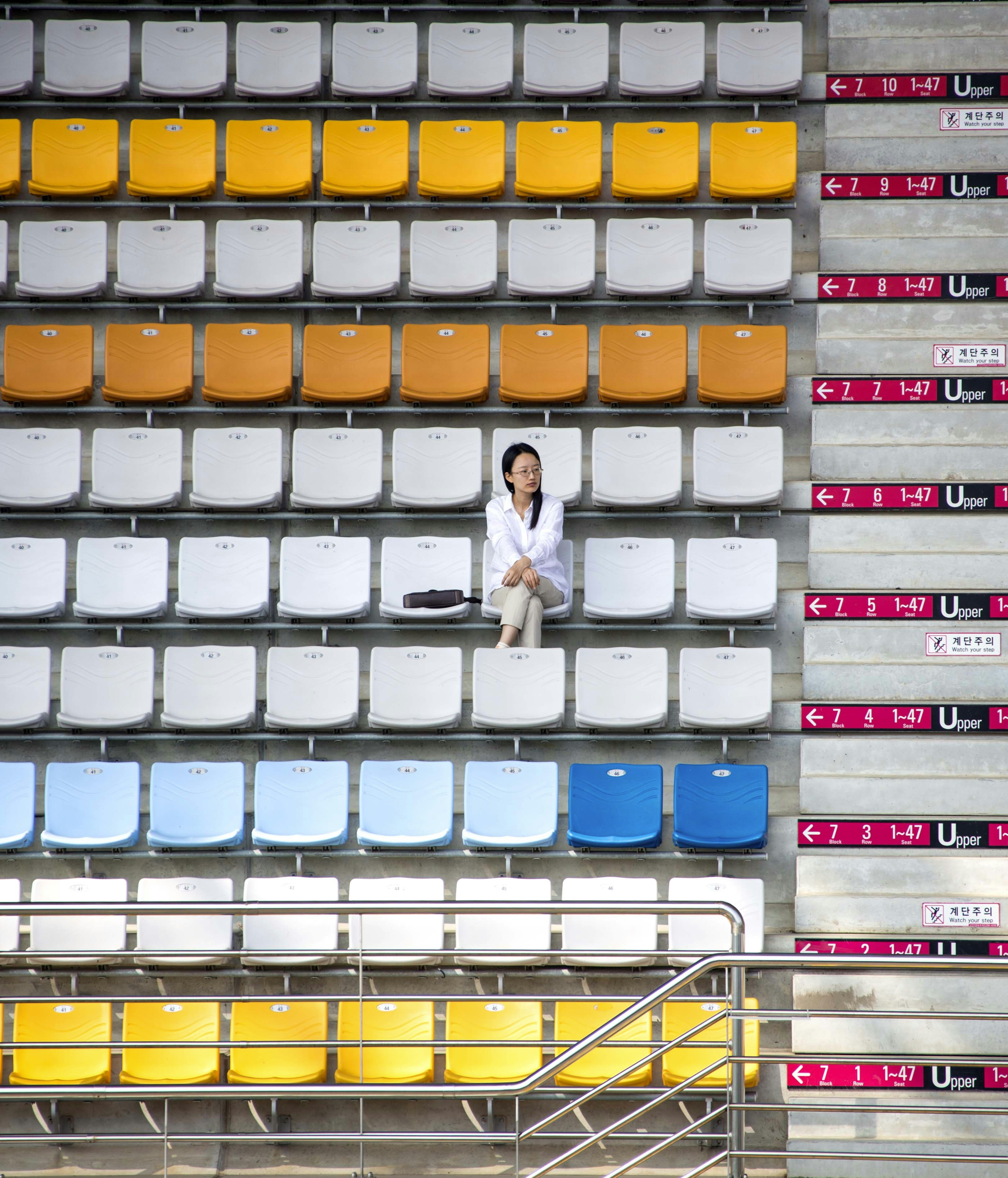 Solitary Observer Amid a Mosaic of Stadium Seats