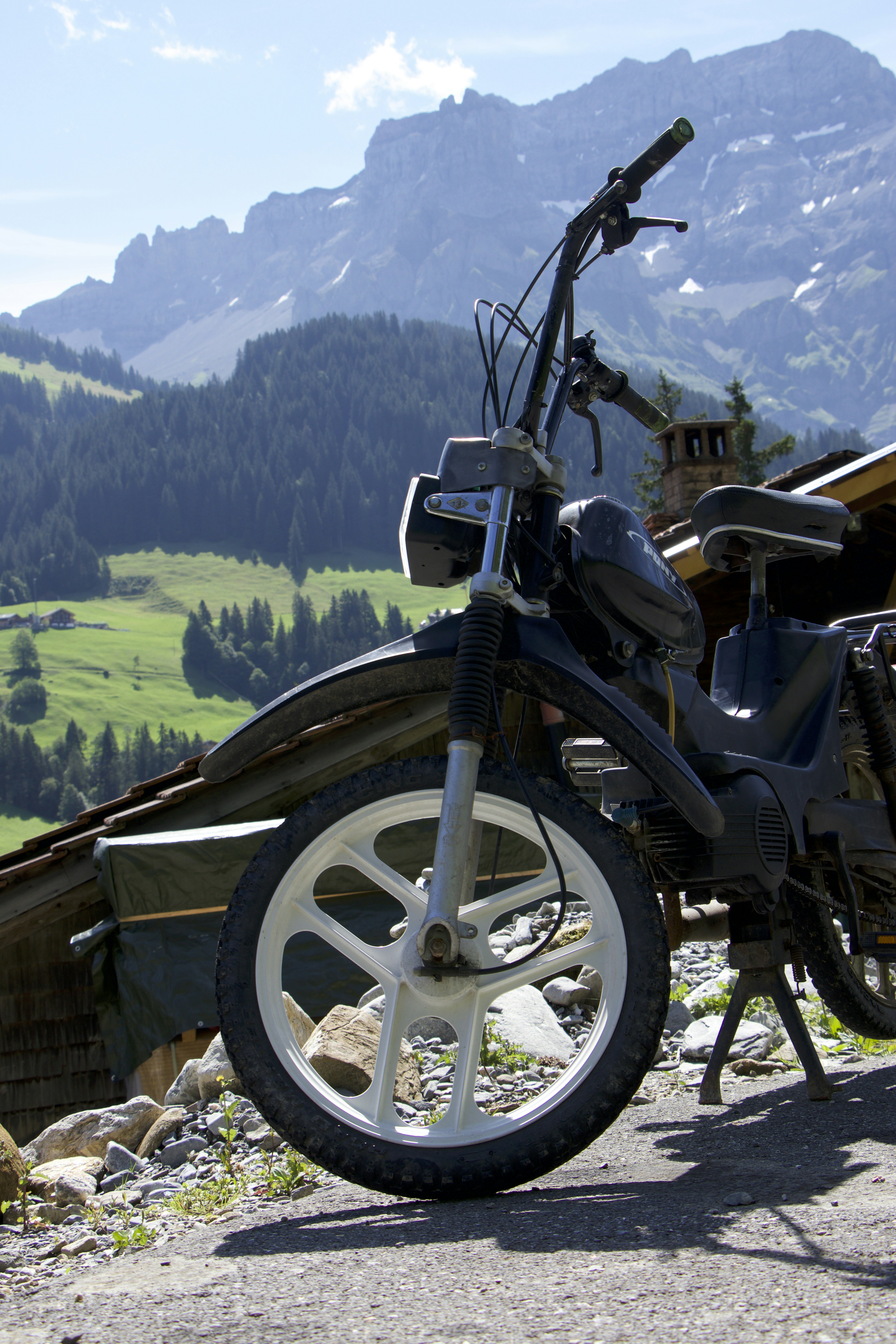 Rugged Pilot: A Motorbike Resting Against a Mountain Backdrop