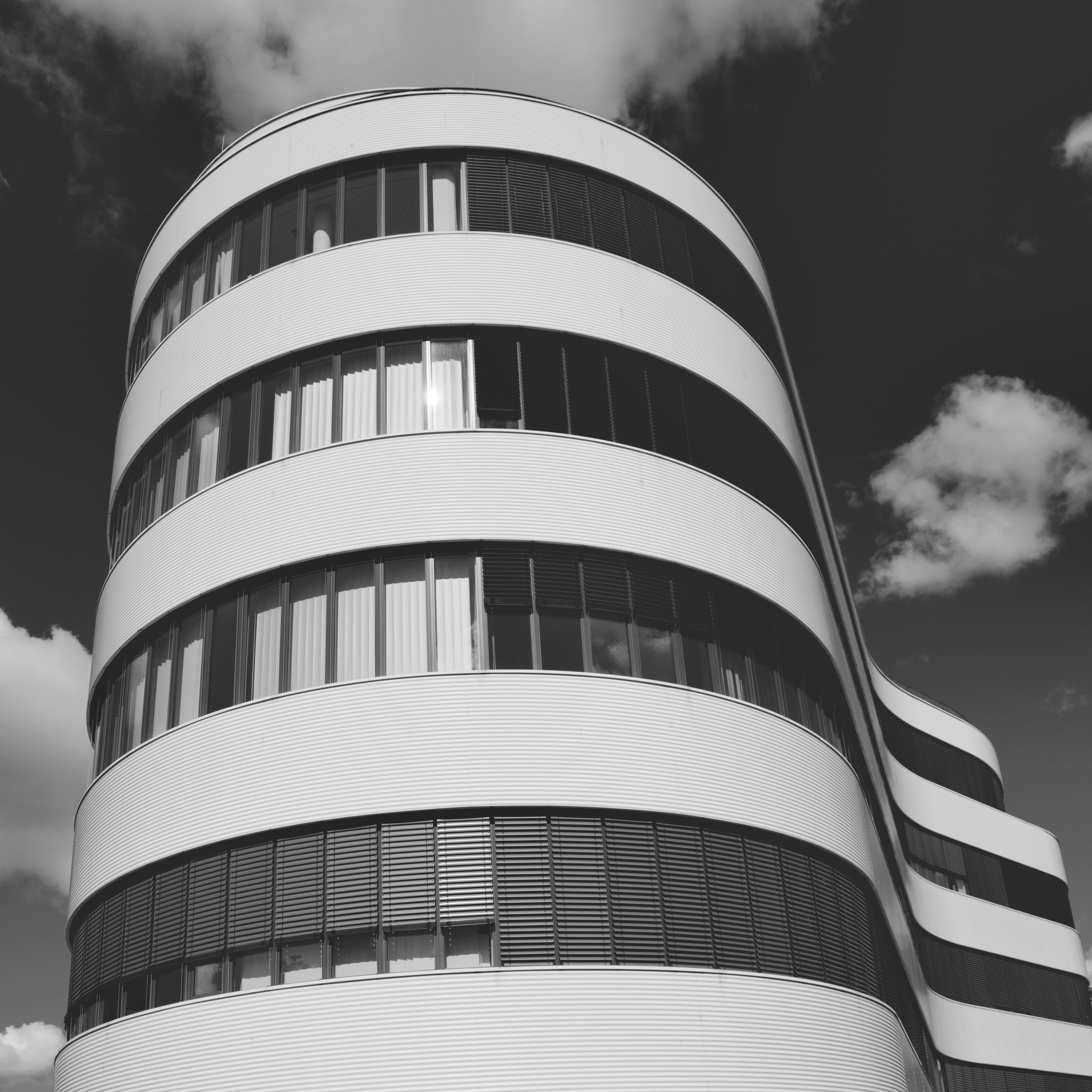 Monochrome Spiral: A Circular Tower's Banded Facade
