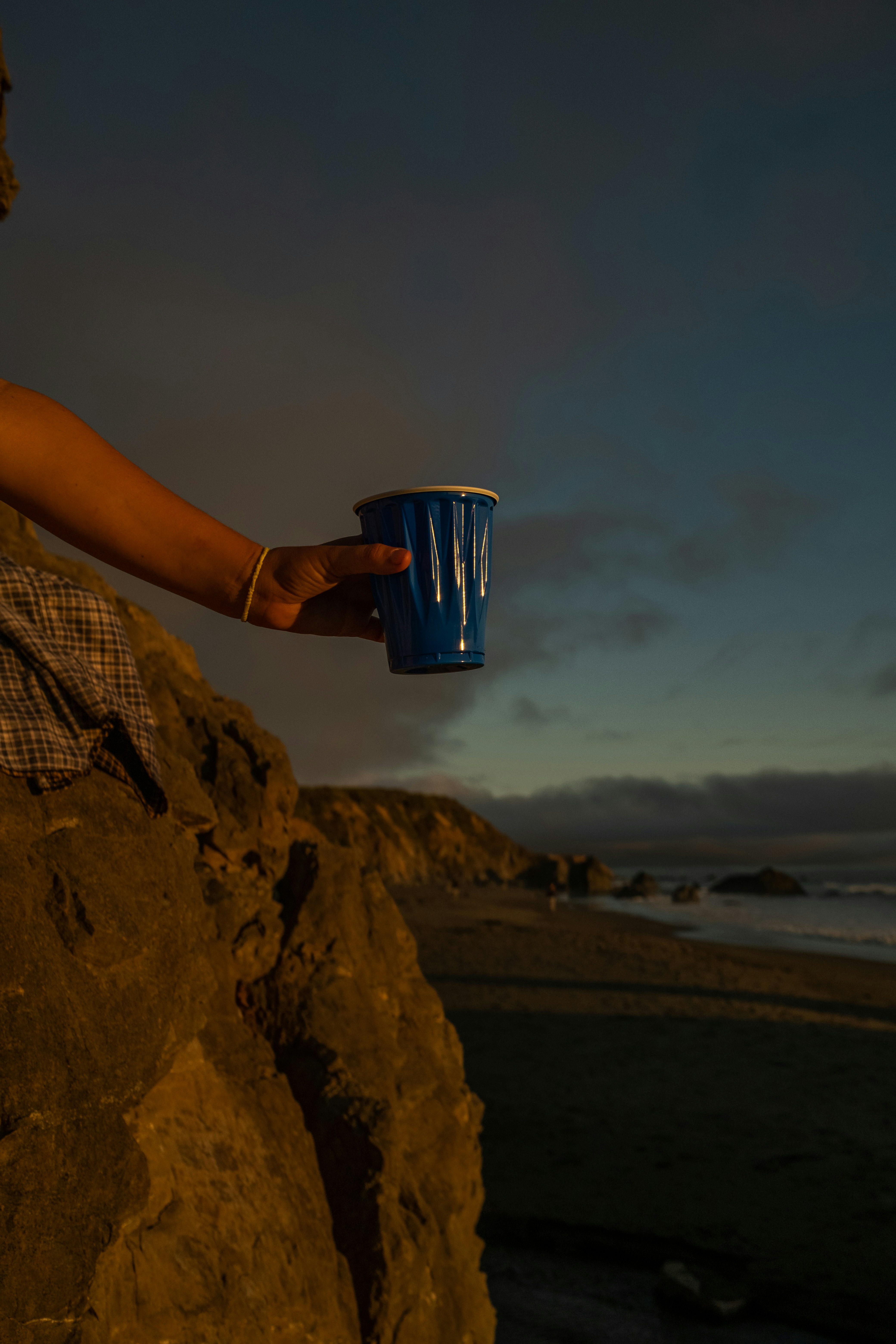 Blue Cup at the Edge: Dusk on a Rocky Shore