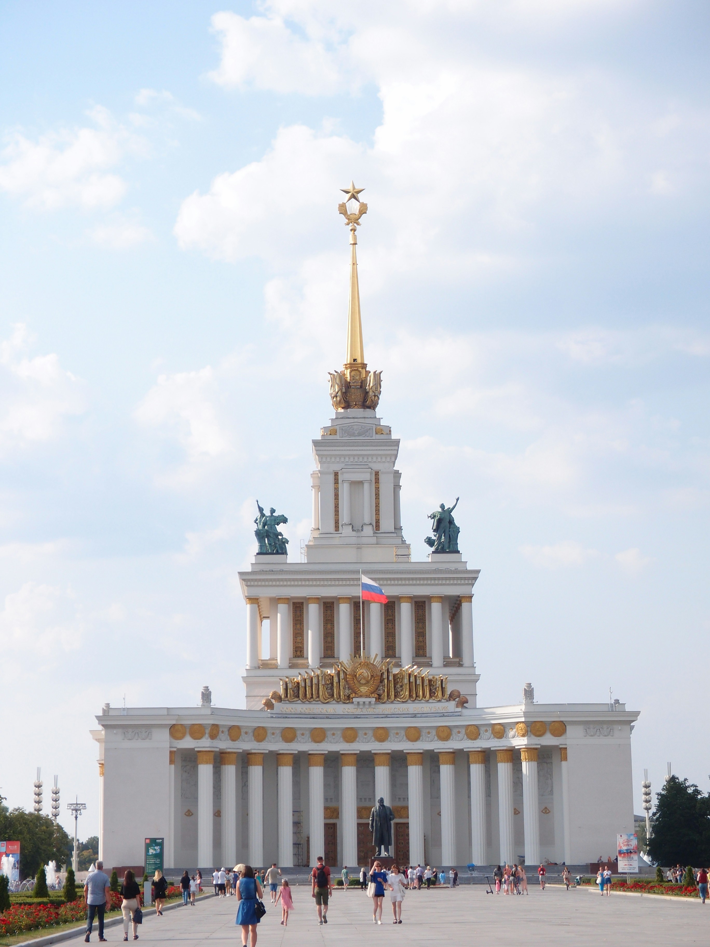 a large white building with a gold statue on top