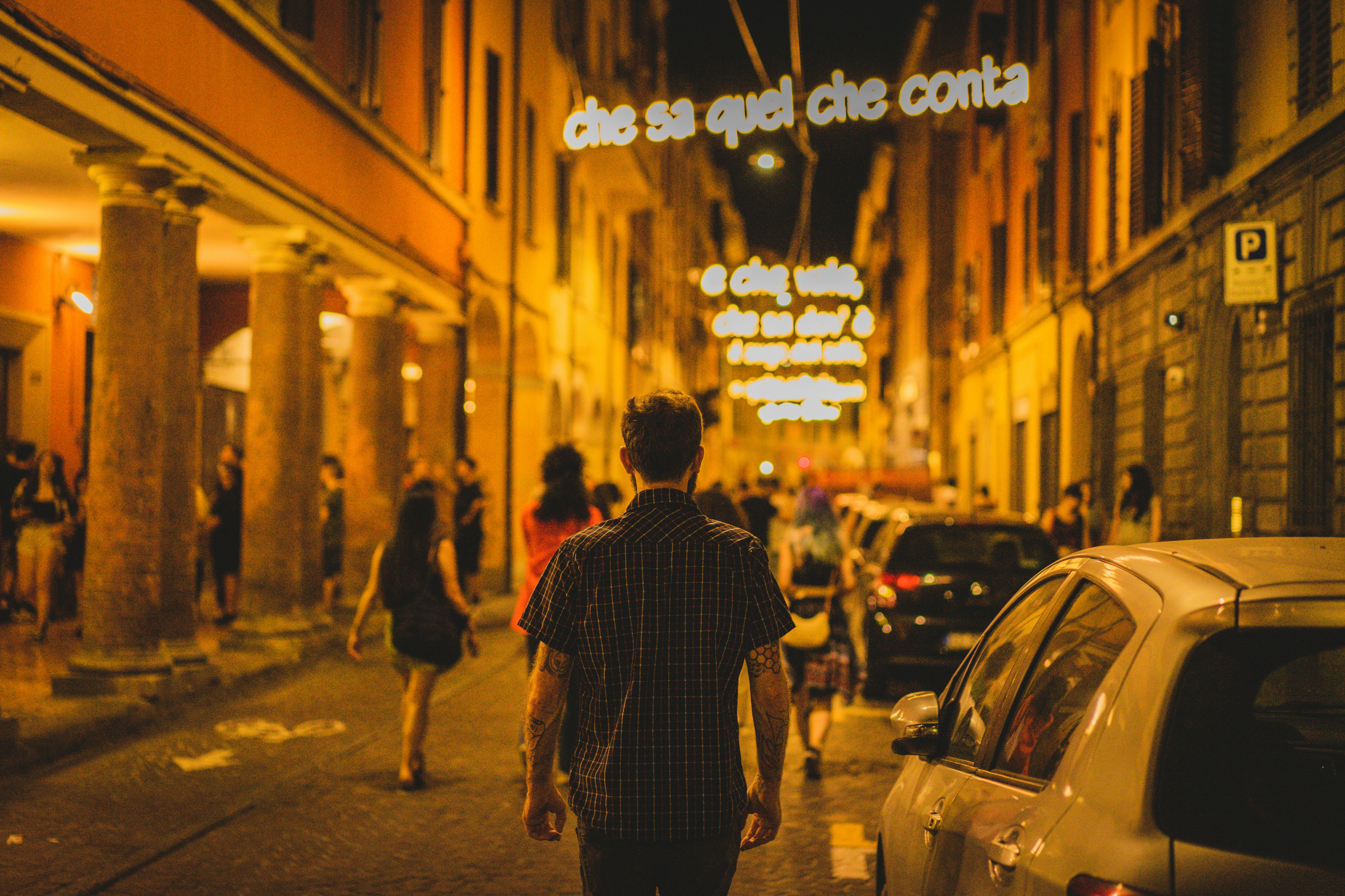 Neon Footsteps: A Lone Walker Through a Warm-Glow Street