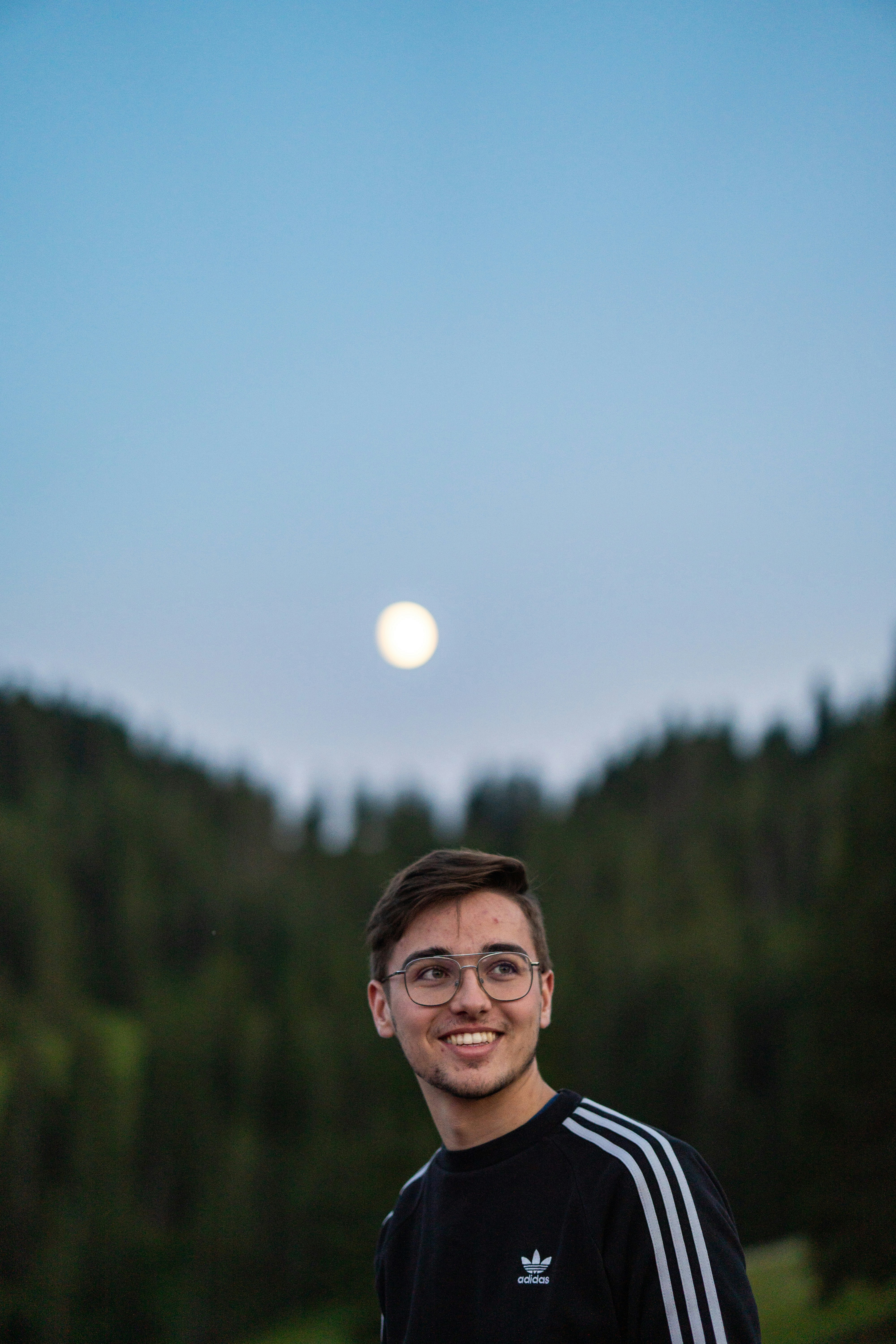 Moonlit Grin: A Portrait beneath a Quiet Evening Sky