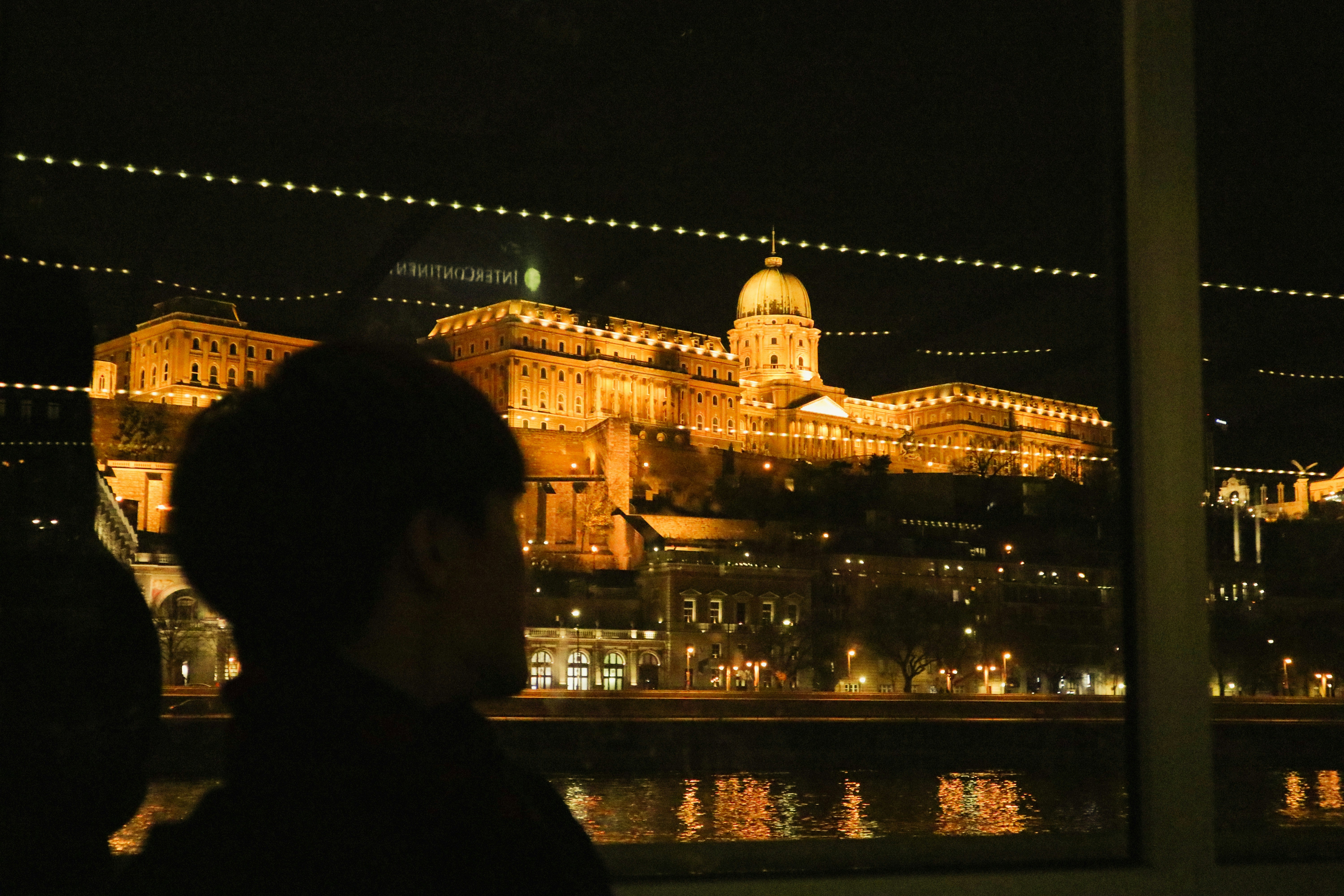 A person looking out a window at a city at night photo – Free Ferry ...