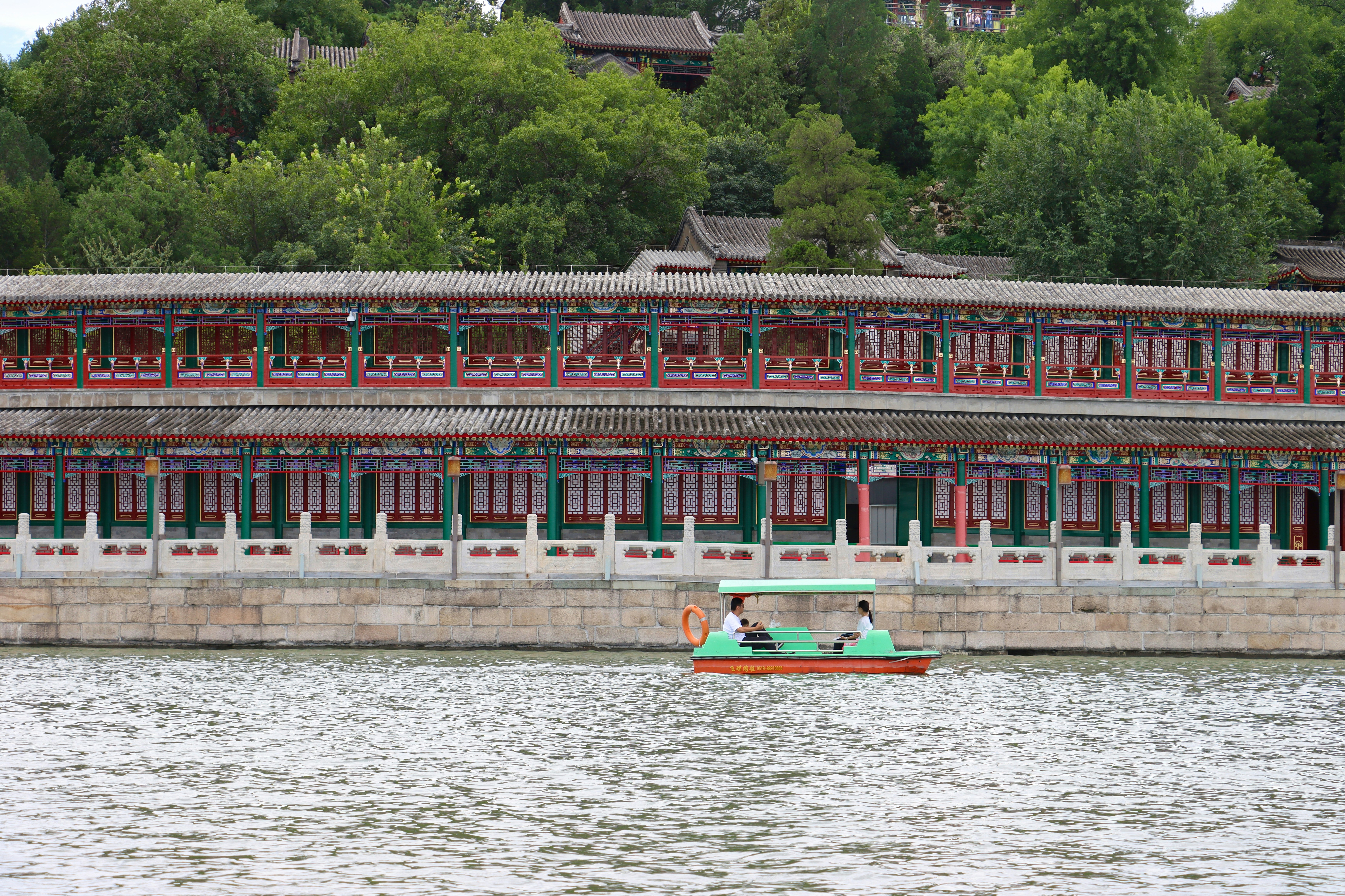 Green Boat Beneath a Tapestry of Riverside Windows