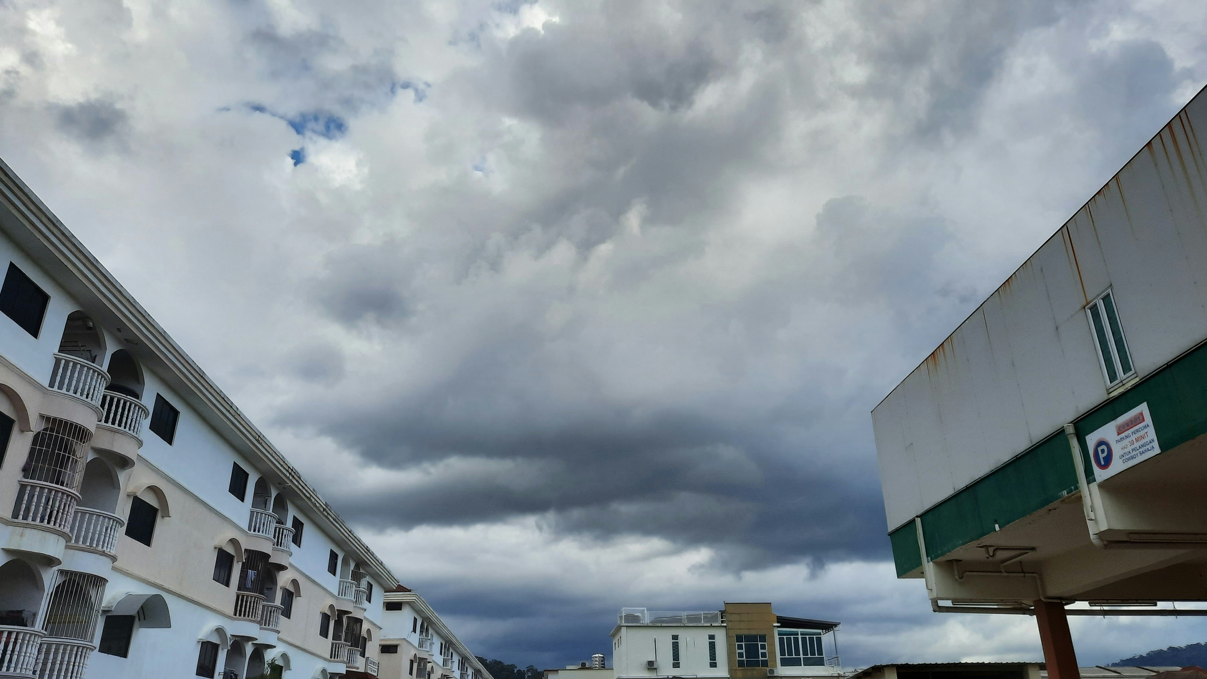 a group of buildings with balconies and a cloudy sky