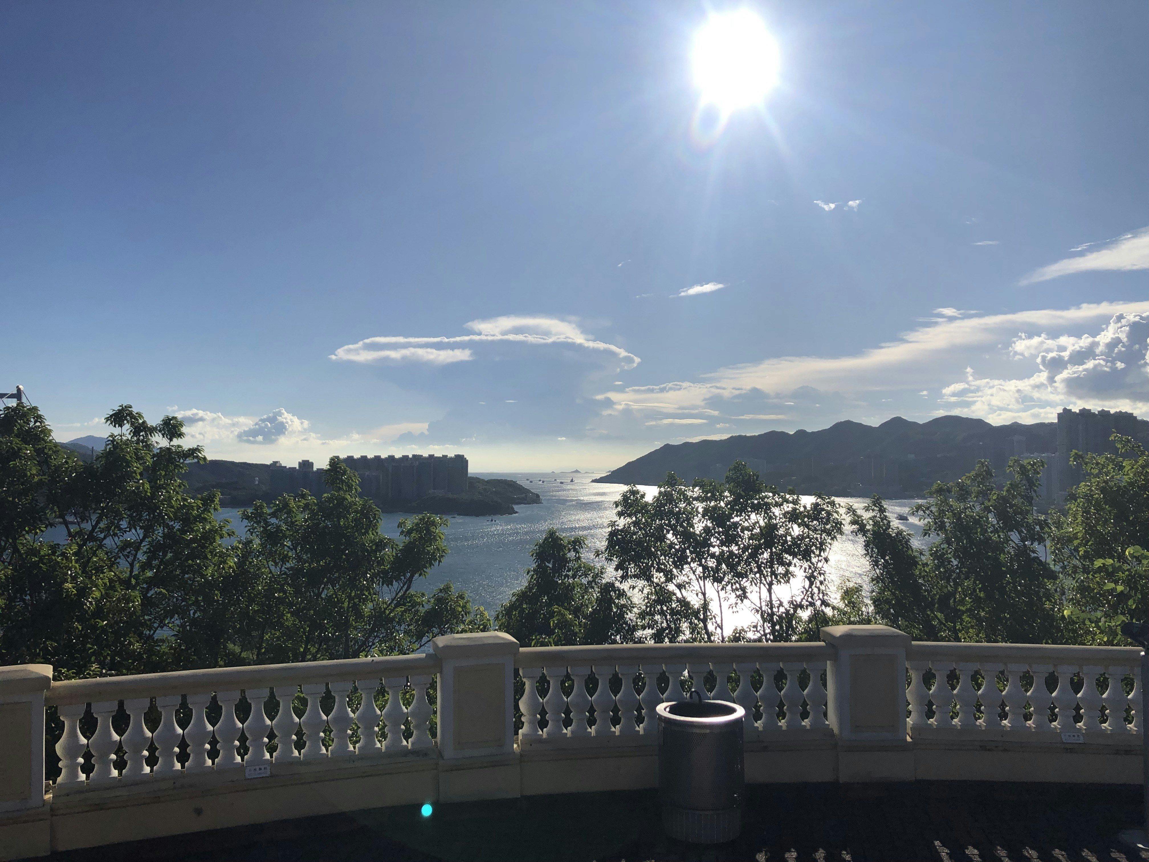 Sunlit cove over a balustrade: coastal vista with shimmering sea