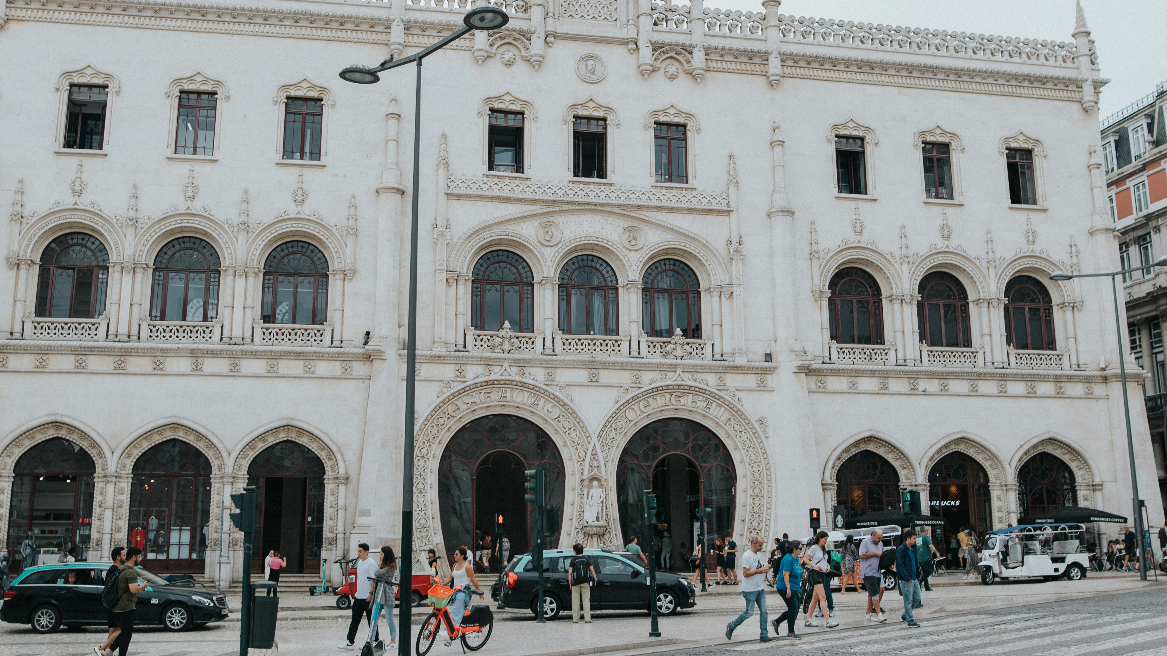Sunlit Arcade: Crowds Before the Grand White Facade