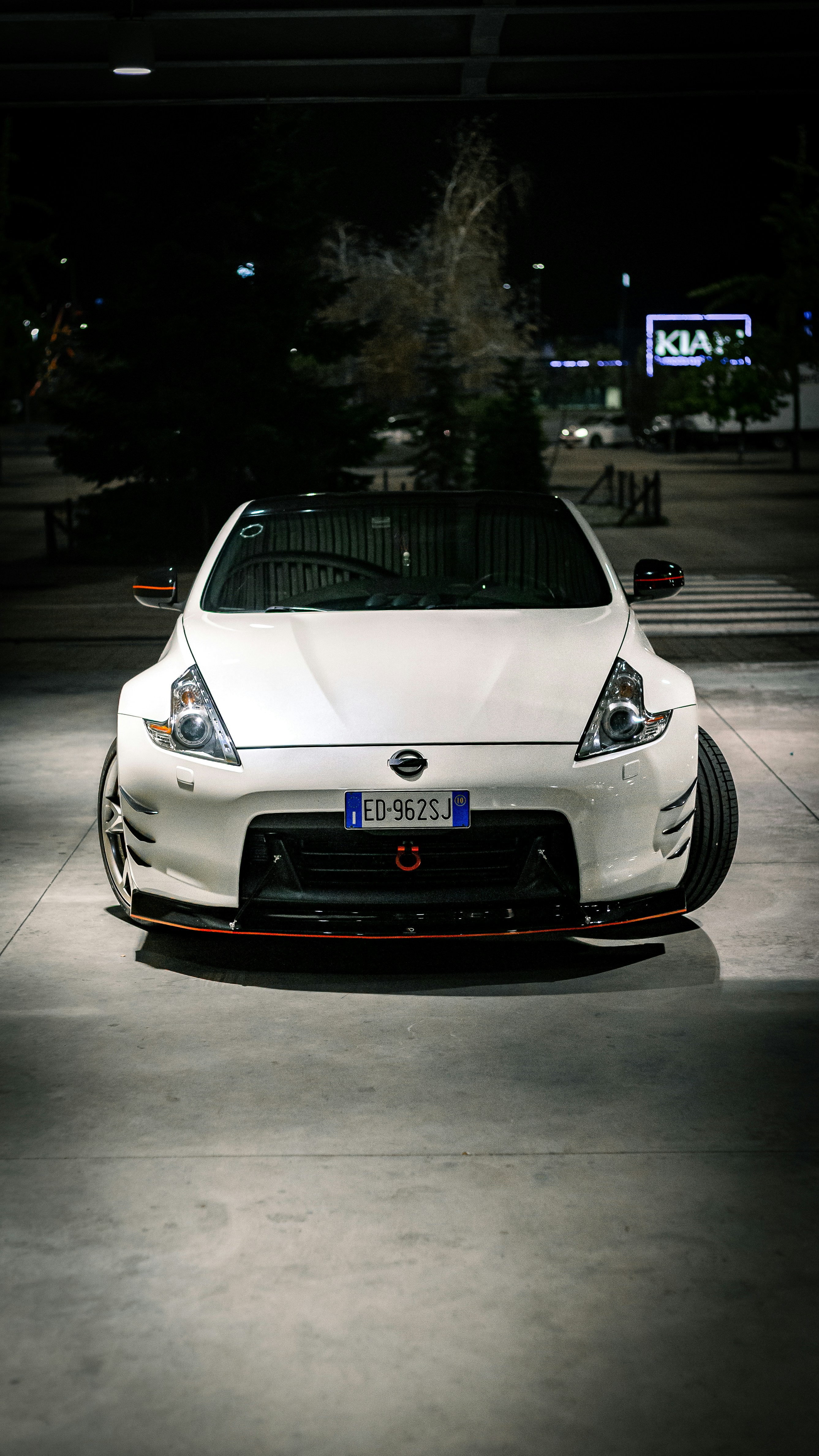 Nightfront Stance: A White Sports Coupe Anchors an Empty Parking Lot