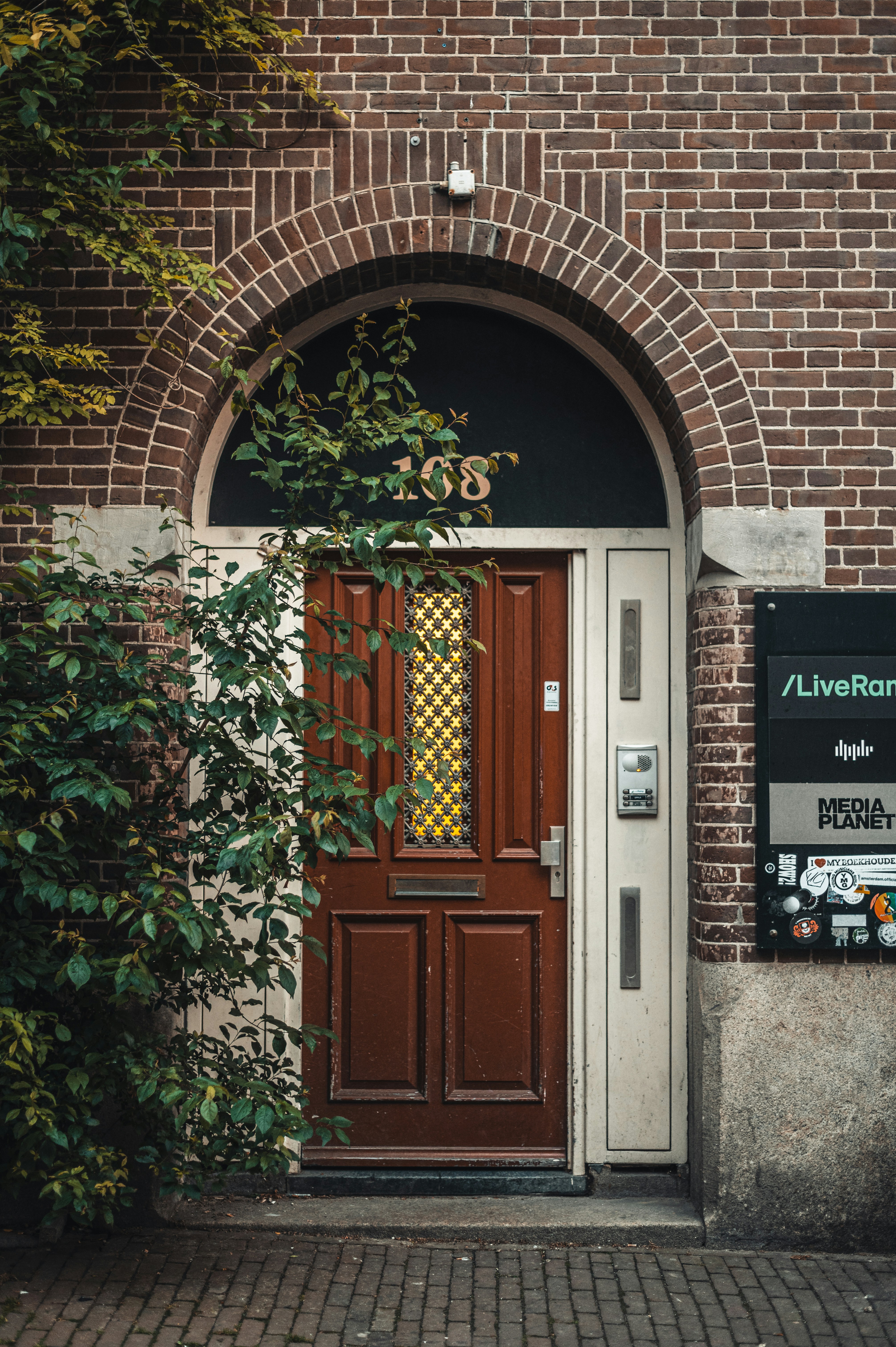 Doorway to a Quiet Street: ivy, brick arch, and a wooden portal