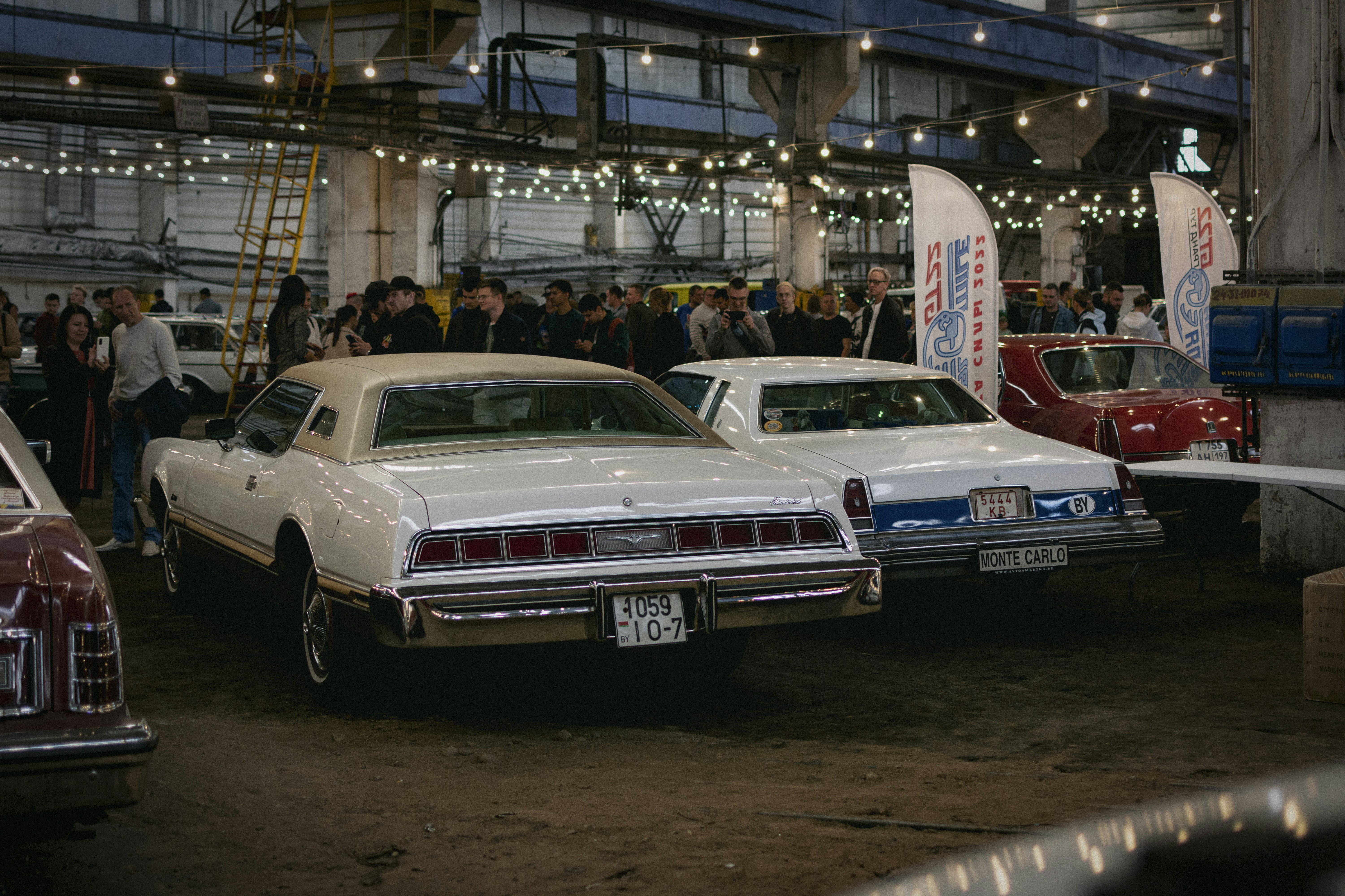 A group of cars parked in a showroom with people standing around photo ...