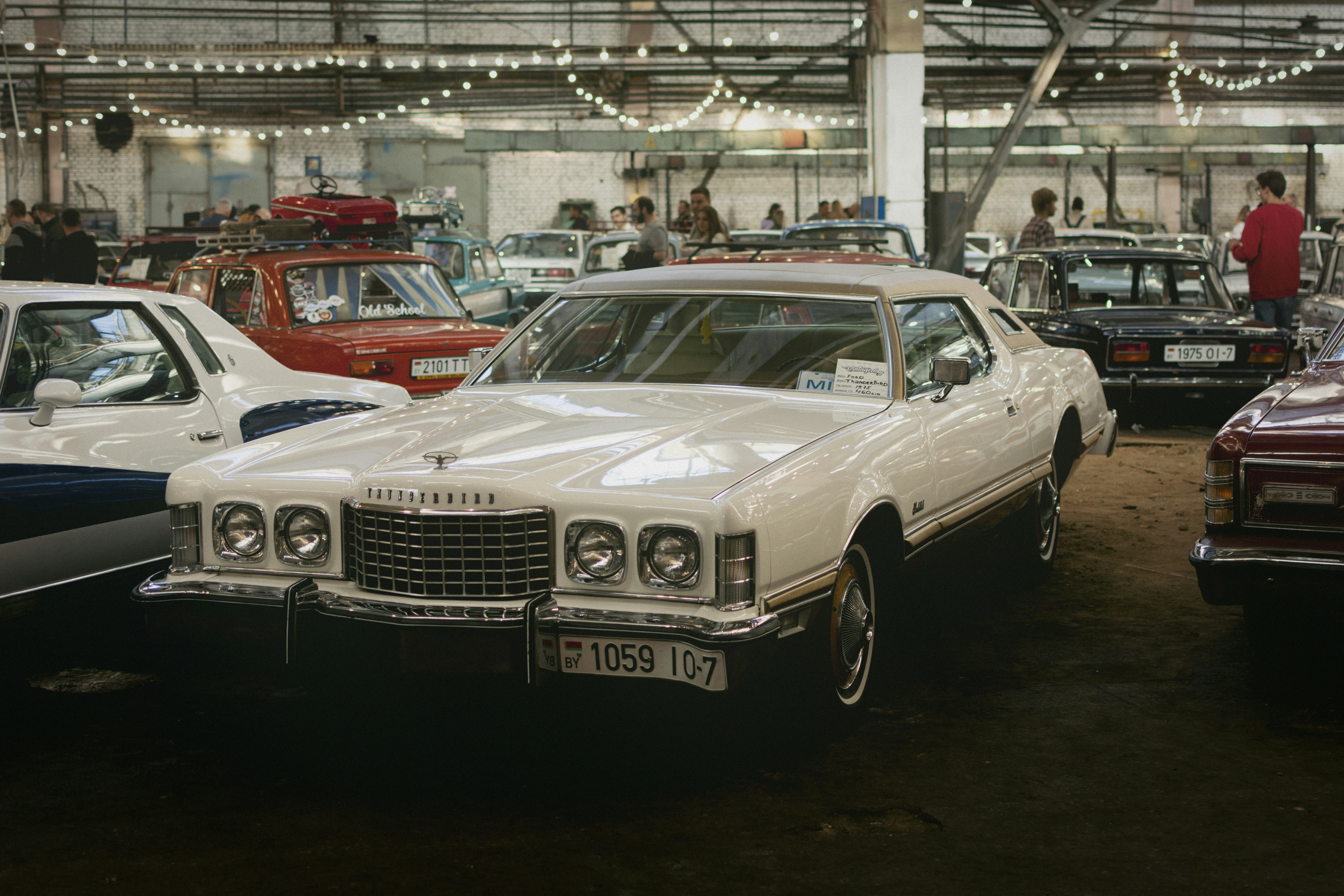 White Vintage Cadillac in a Bustling Indoor Car Show