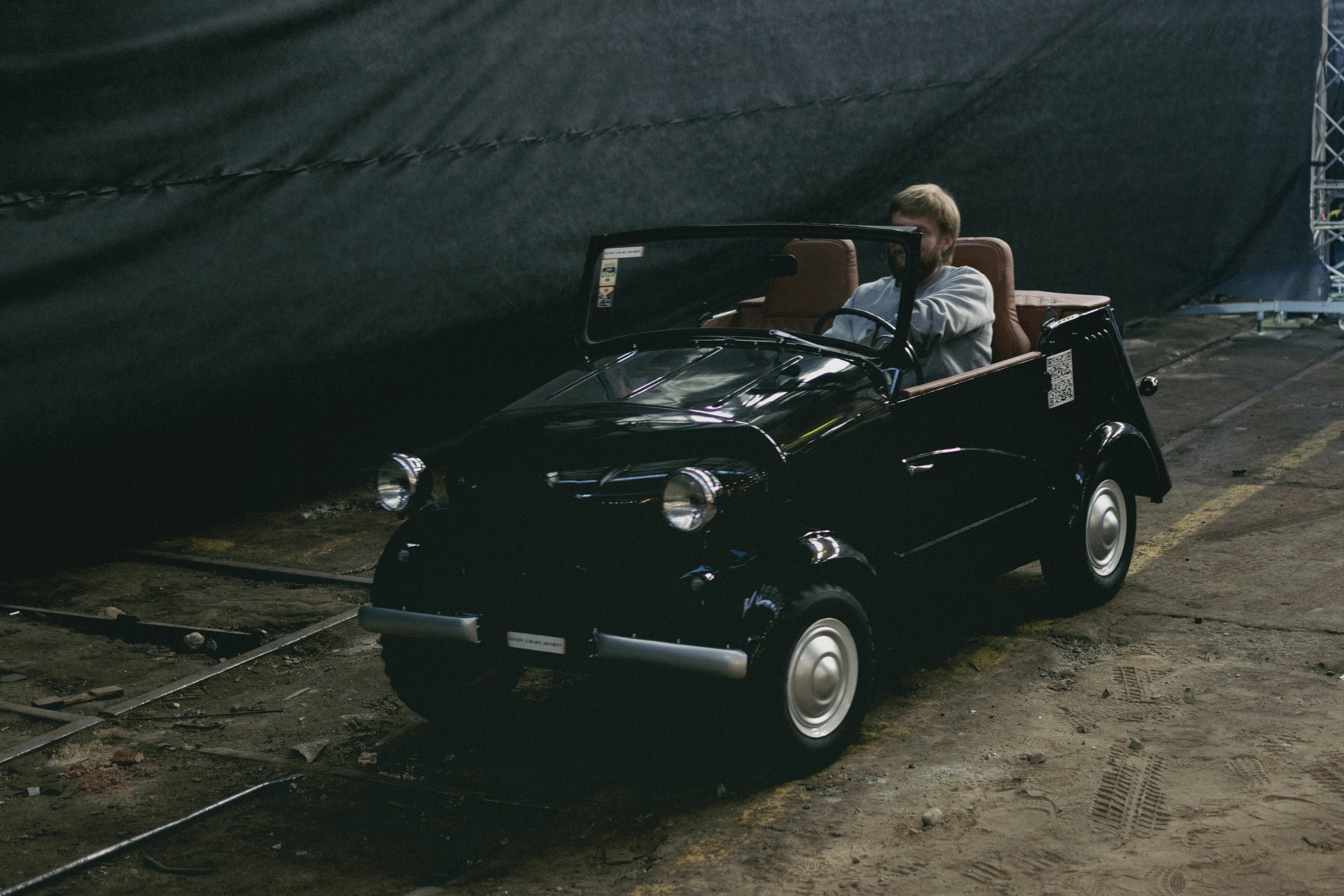 Miniature Ride, Large Ambition: A Tiny Convertible on a Dim Stage